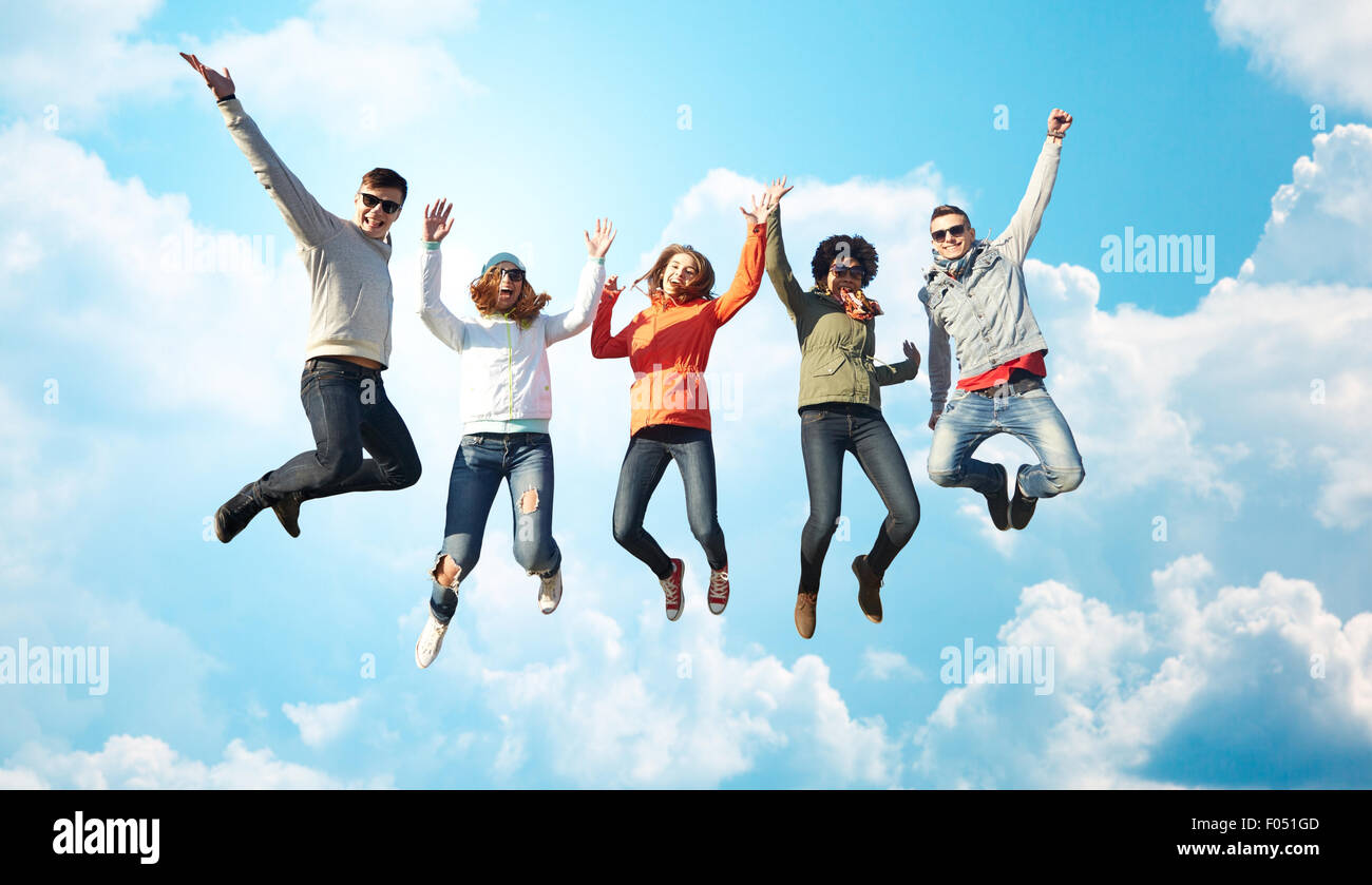 smiling friends in sunglasses jumping high Stock Photo - Alamy