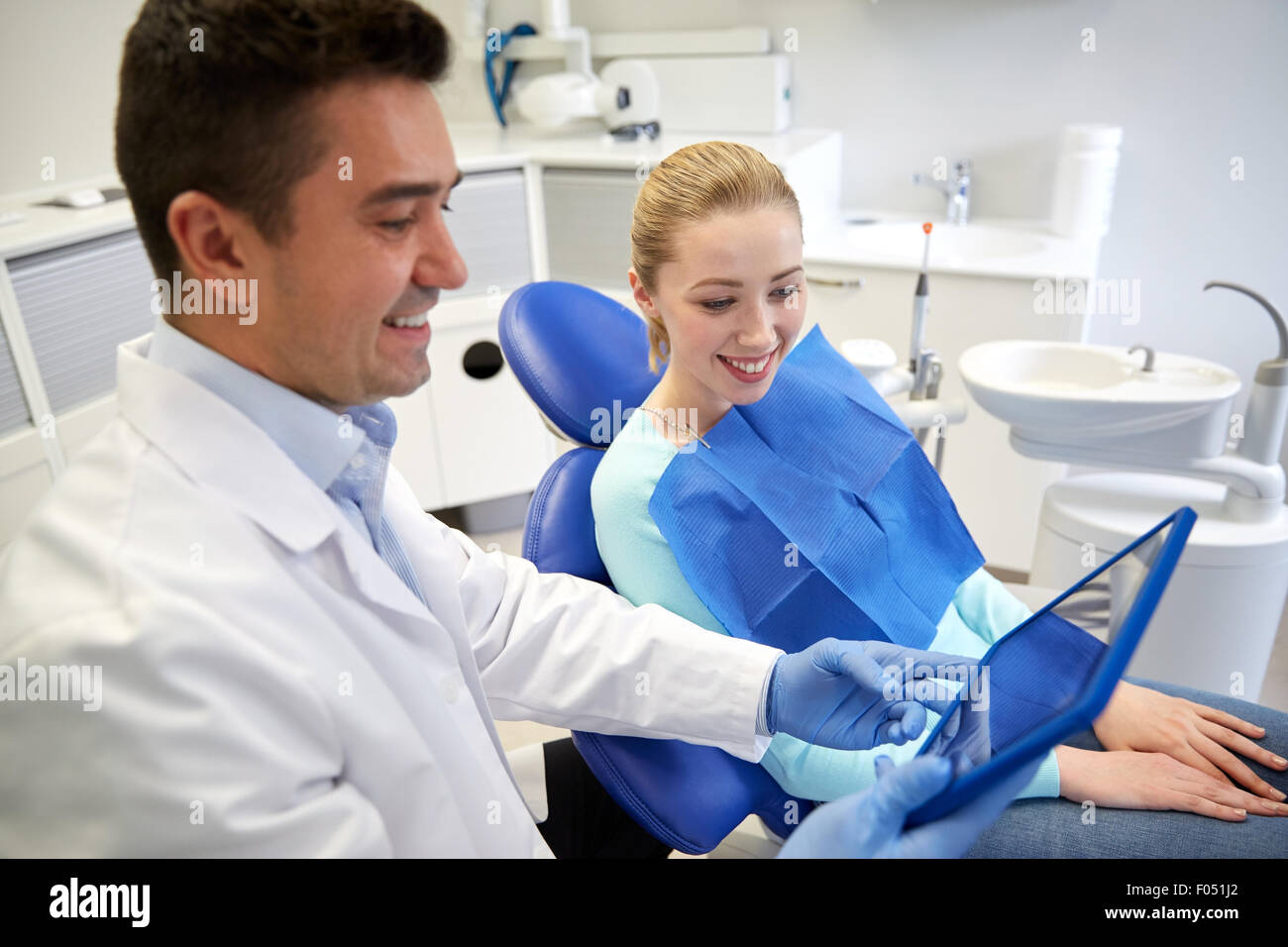 male dentist with tablet pc and woman patient Stock Photo - Alamy