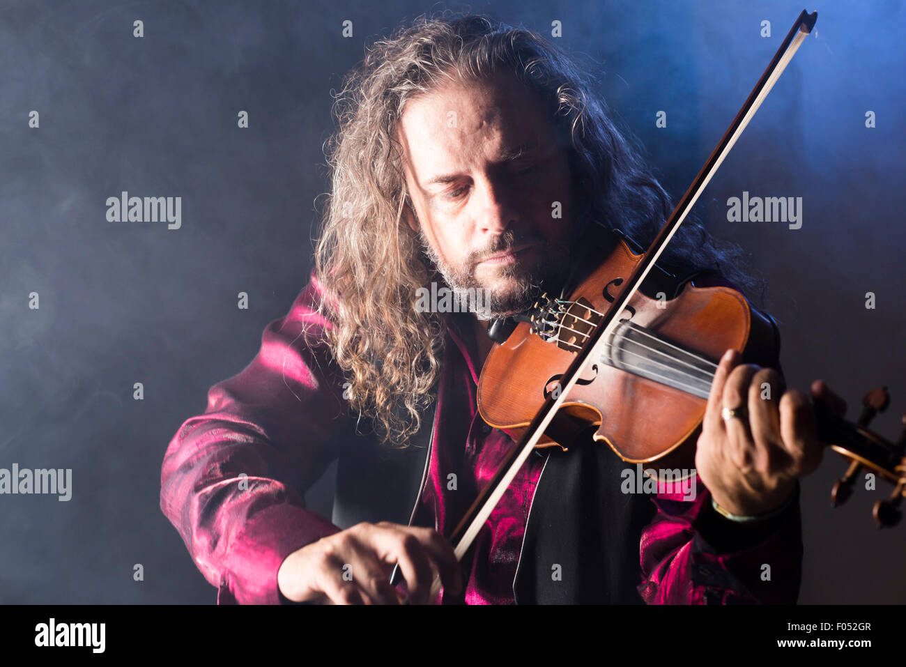 handsome man playing classical violin through blue smoke Stock Photo ...