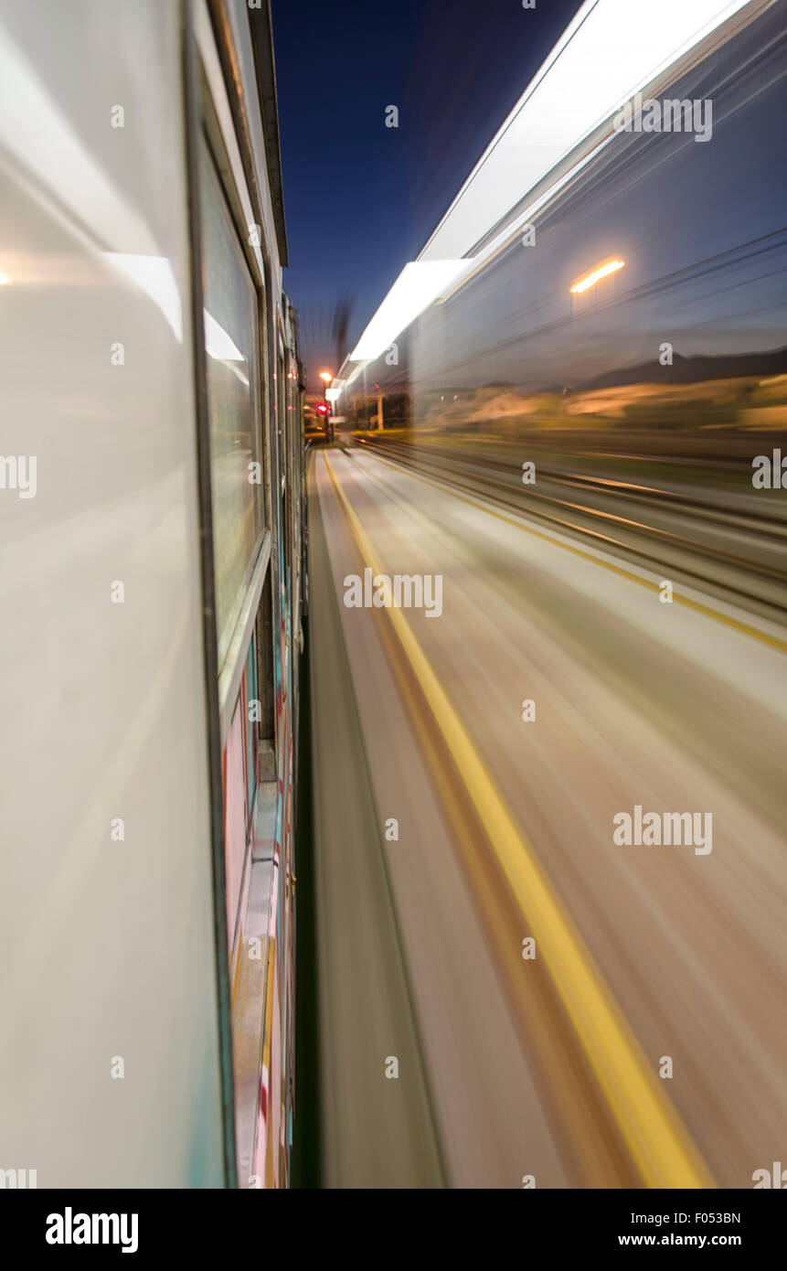 Train at full speed crossing the station Stock Photo - Alamy