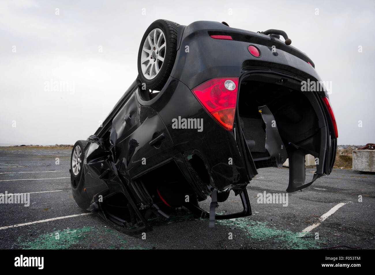 Black car turned upside-down after road collision Stock Photo - Alamy
