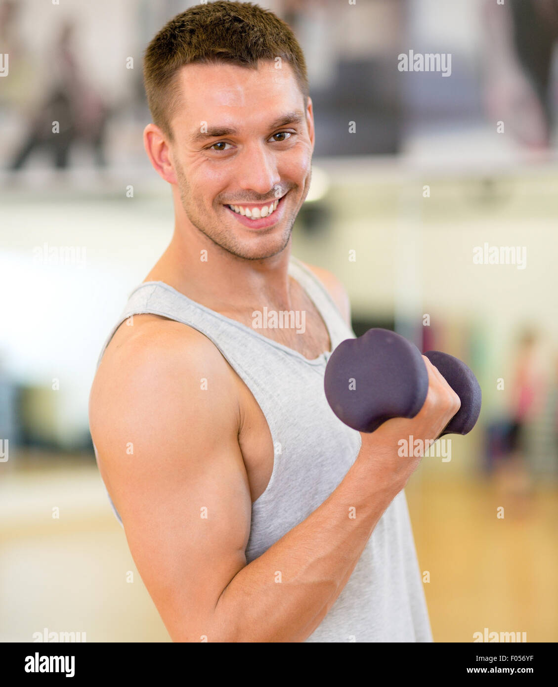 smiling man with dumbbell in gym Stock Photo - Alamy