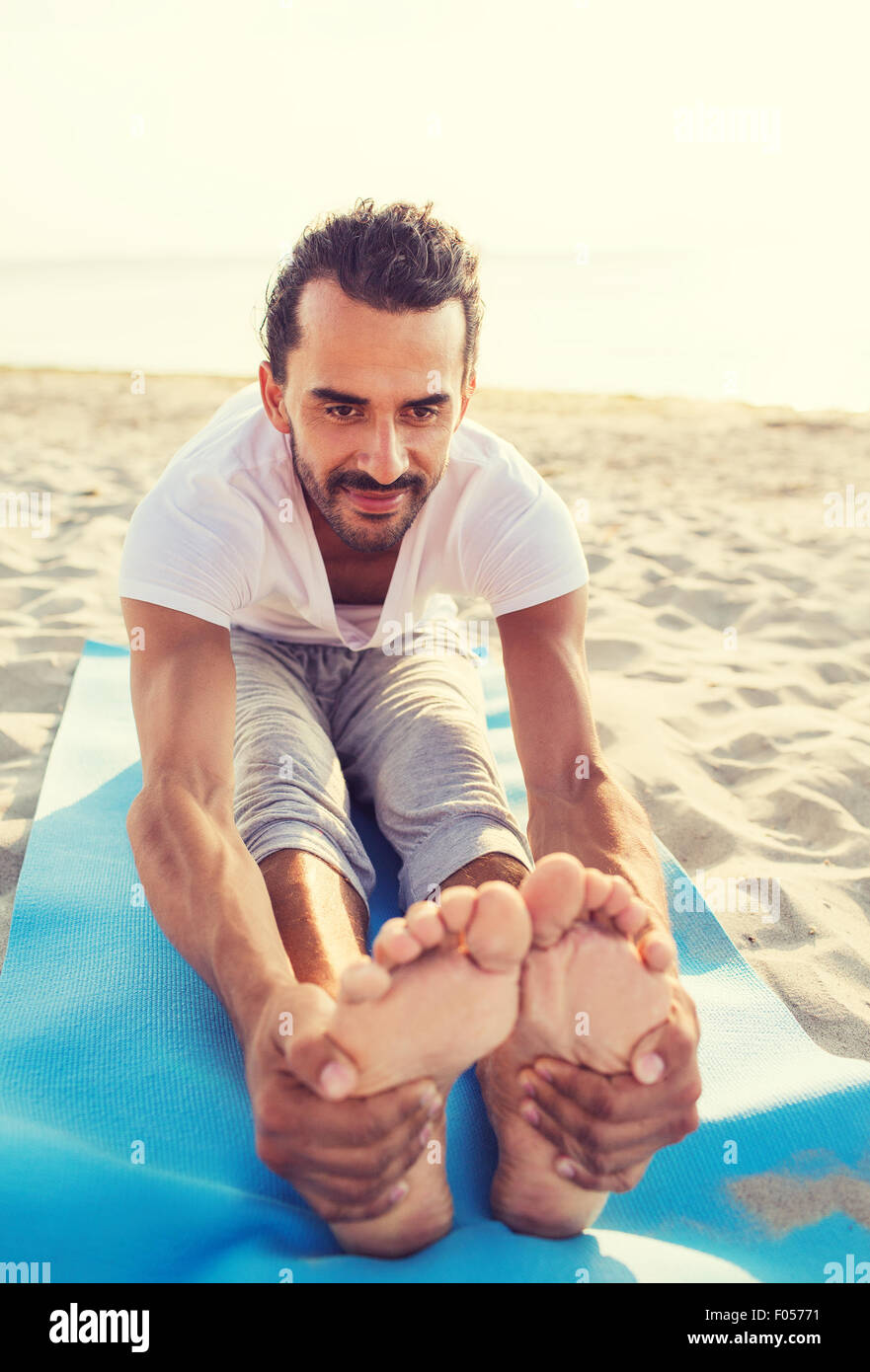 man doing yoga exercises outdoors Stock Photo - Alamy
