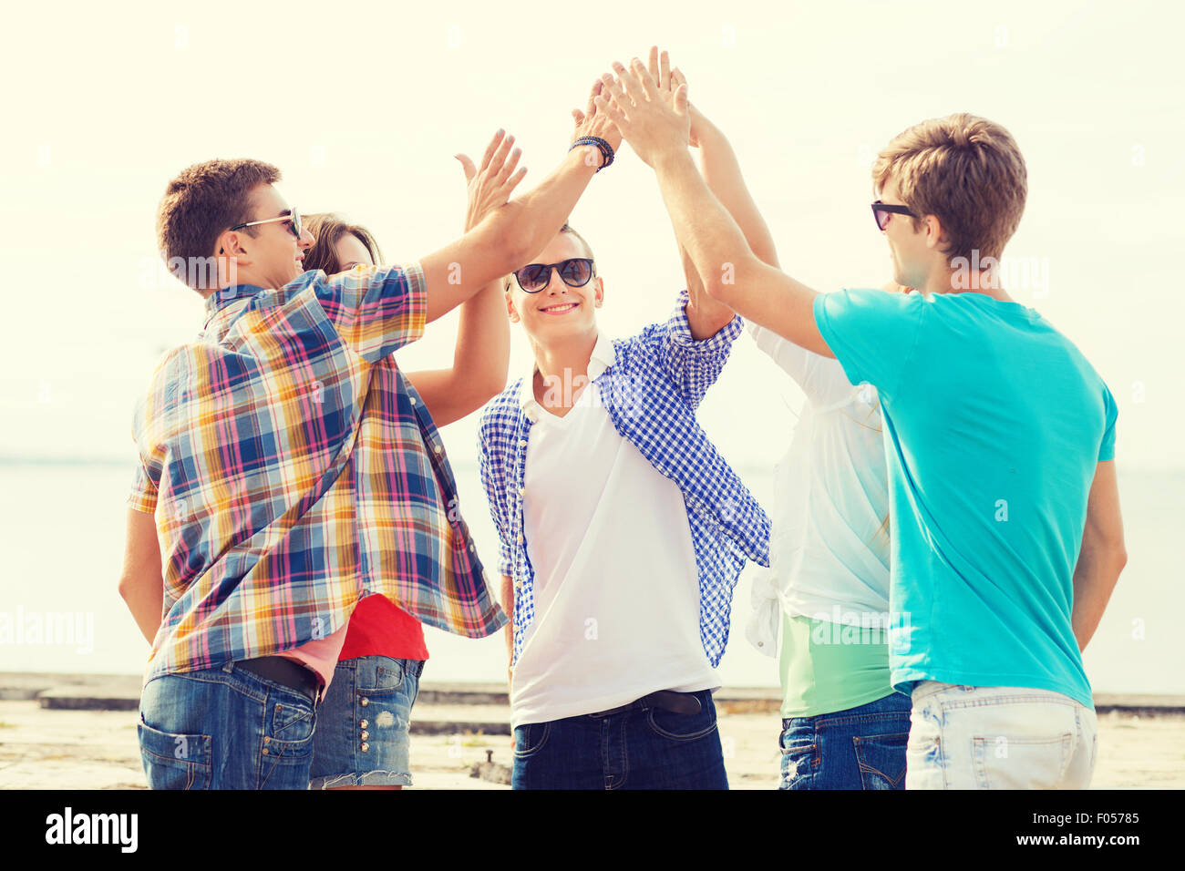 group of smiling friends making high five outdoors Stock Photo - Alamy