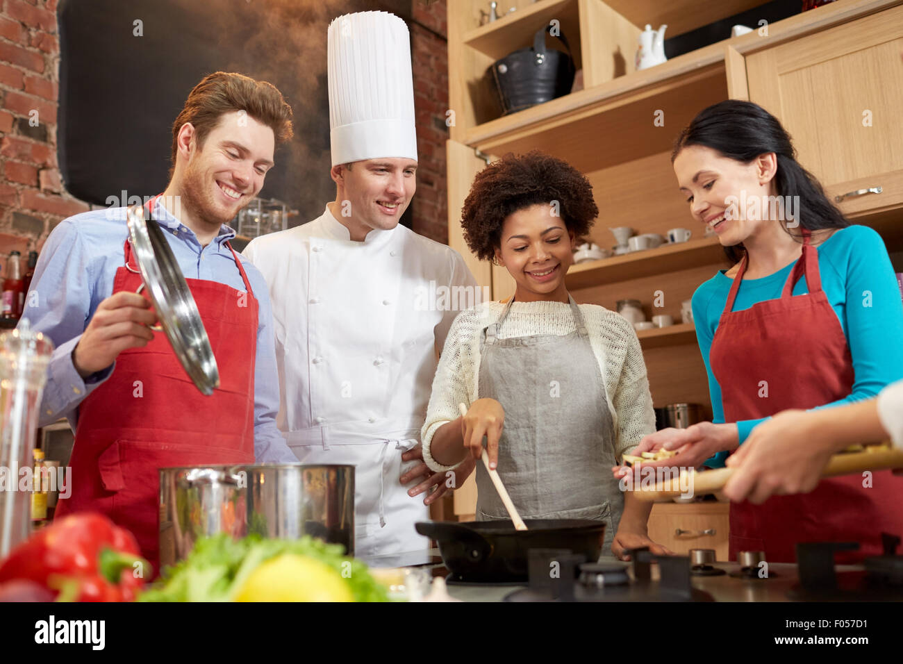happy friends and chef cook cooking in kitchen Stock Photo - Alamy