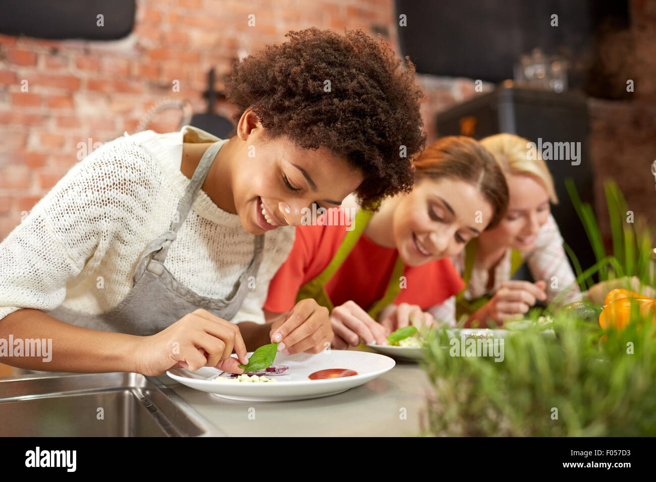 happy women cooking and decorating dishes Stock Photo - Alamy