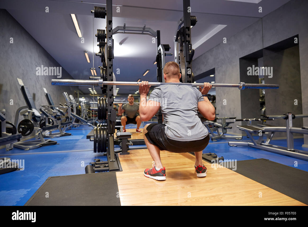 young man flexing muscles with bar in gym Stock Photo - Alamy