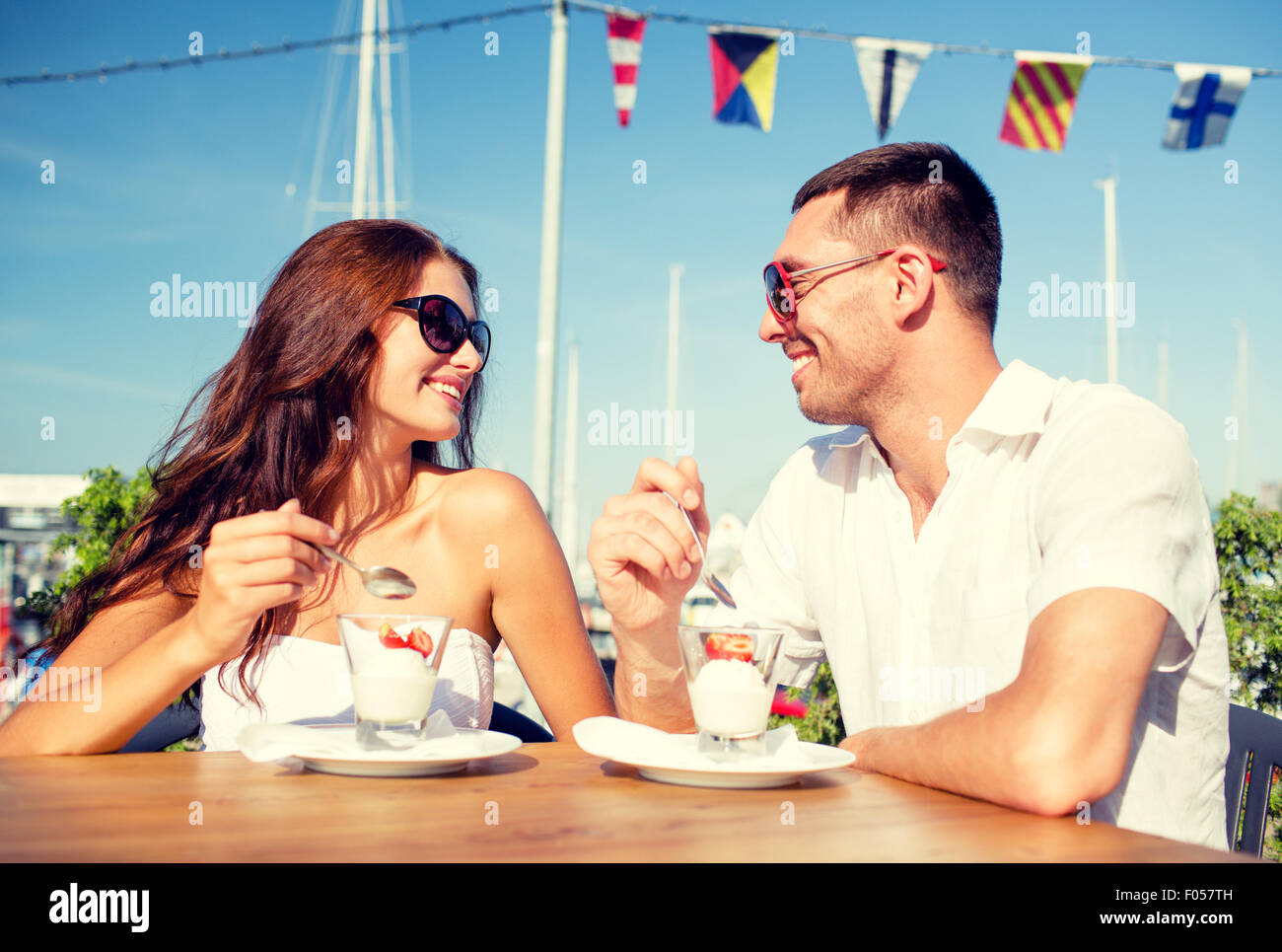 smiling couple eating dessert at cafe Stock Photo - Alamy