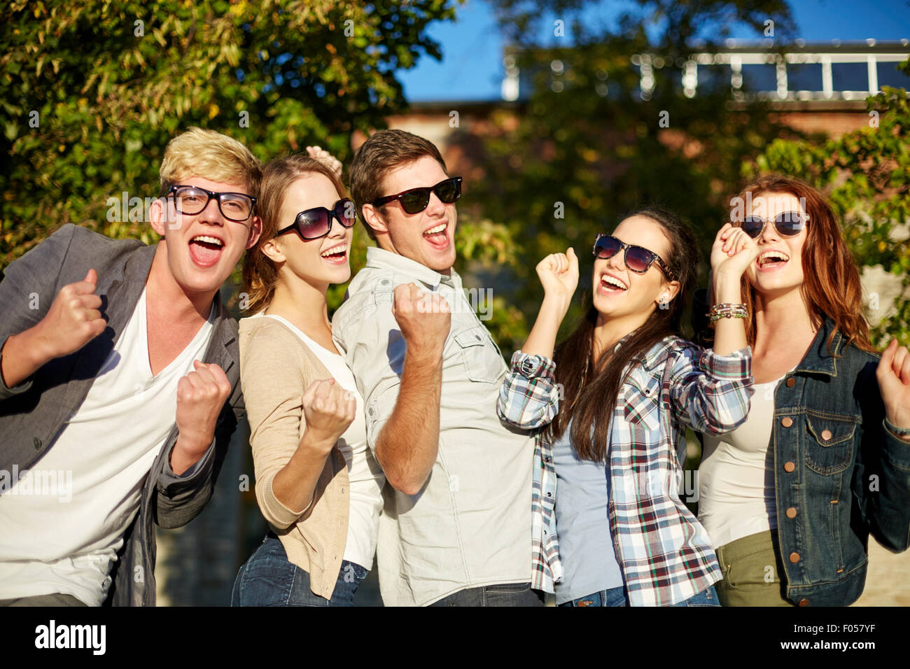 group of happy friends showing triumph gesture Stock Photo - Alamy