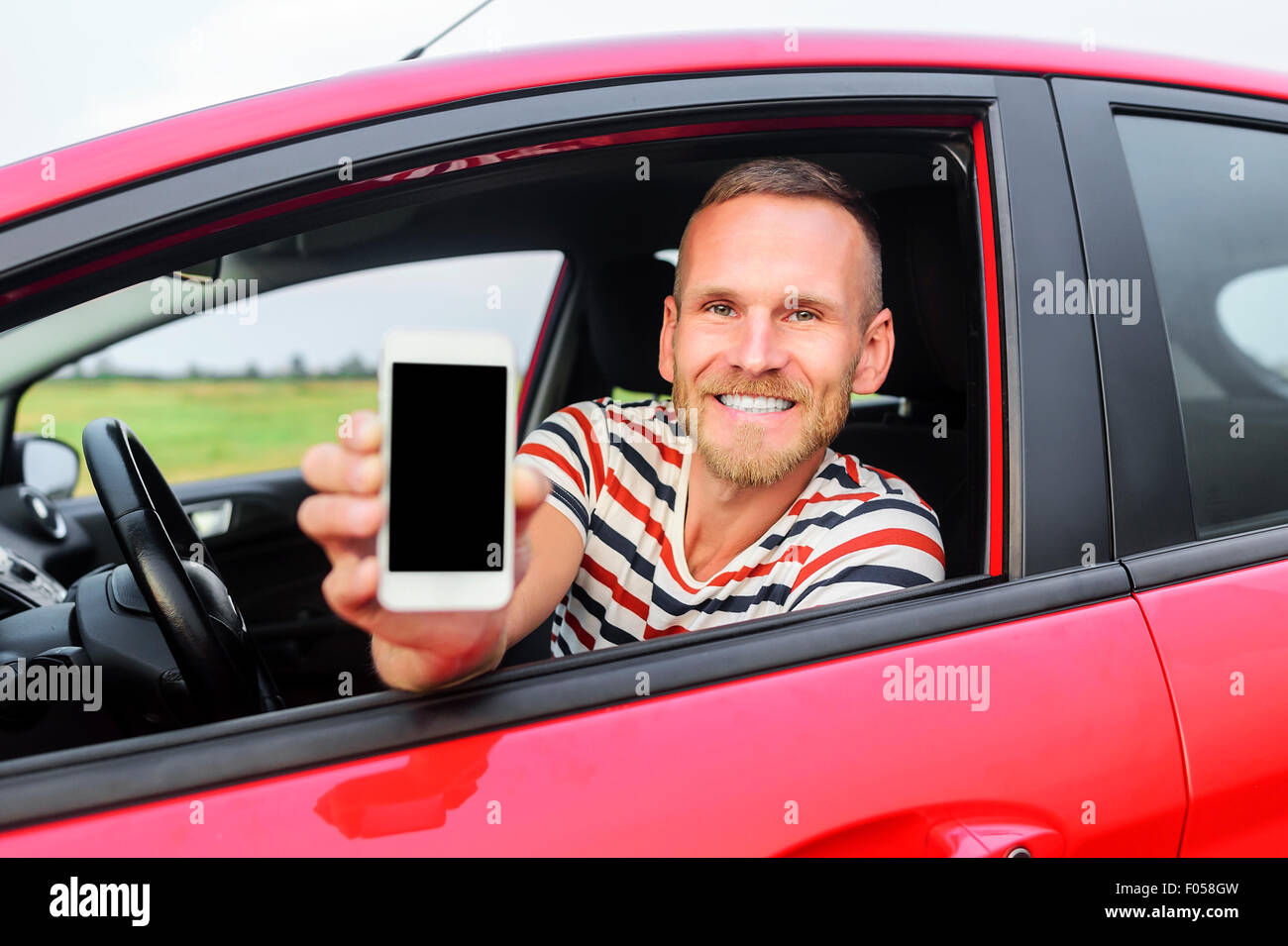 Man in car showing smart phone Stock Photo - Alamy
