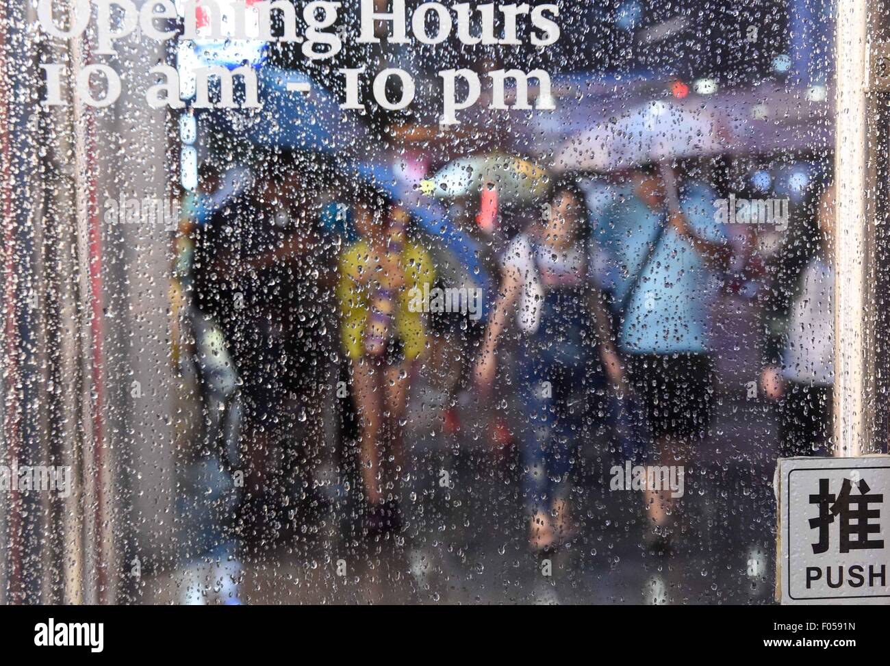 Beijing, China. 7th Aug, 2015. People walk in the rain in Beijing ...