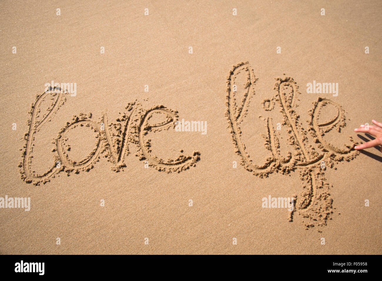 The words love life written in the sand Stock Photo - Alamy
