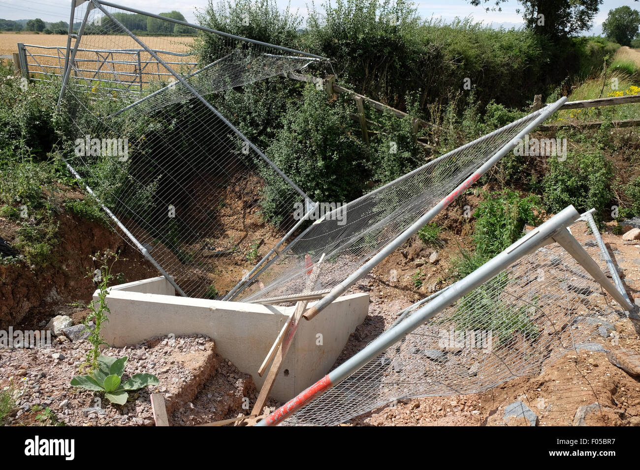 fencing around a drainage ditch that as blown over Stock Photo - Alamy