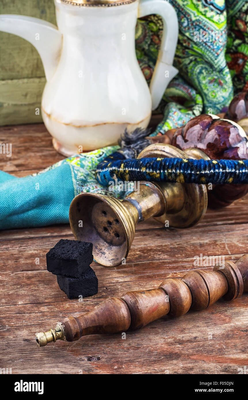 Old smoking hookah on wooden surface.Photo tinted Stock Photo - Alamy