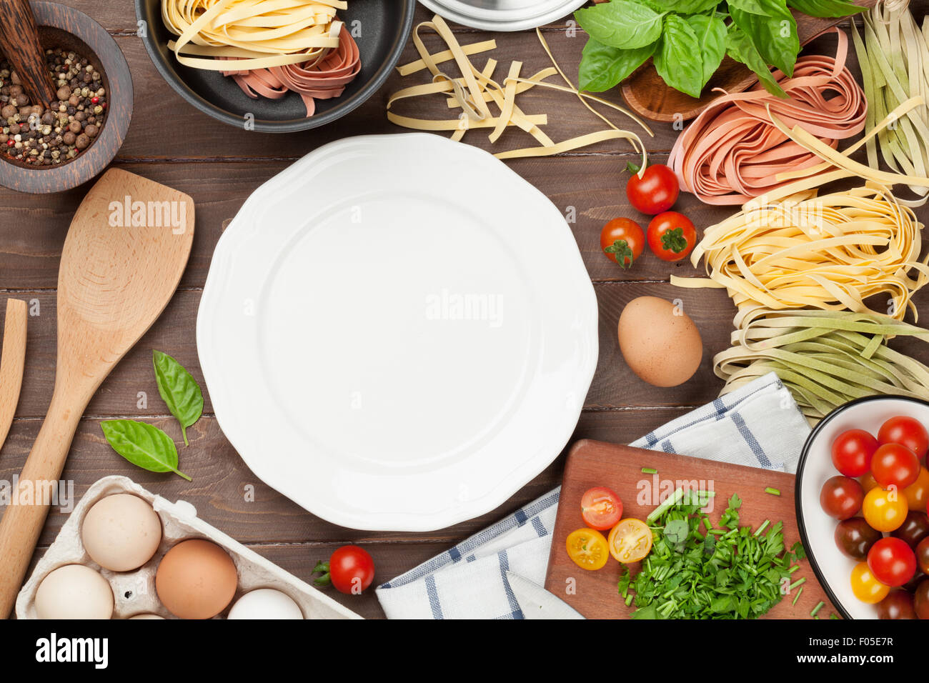 Pasta cooking ingredients and utensils on wooden table. Top view with ...