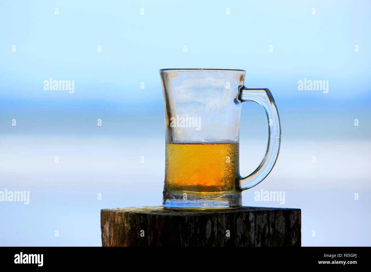 Beer glass at the edge of a blue background Stock Photo - Alamy
