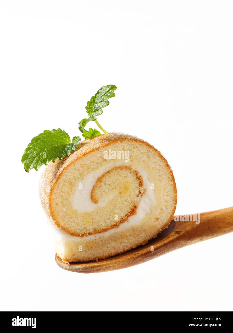 Swiss roll on wooden spoon Stock Photo - Alamy