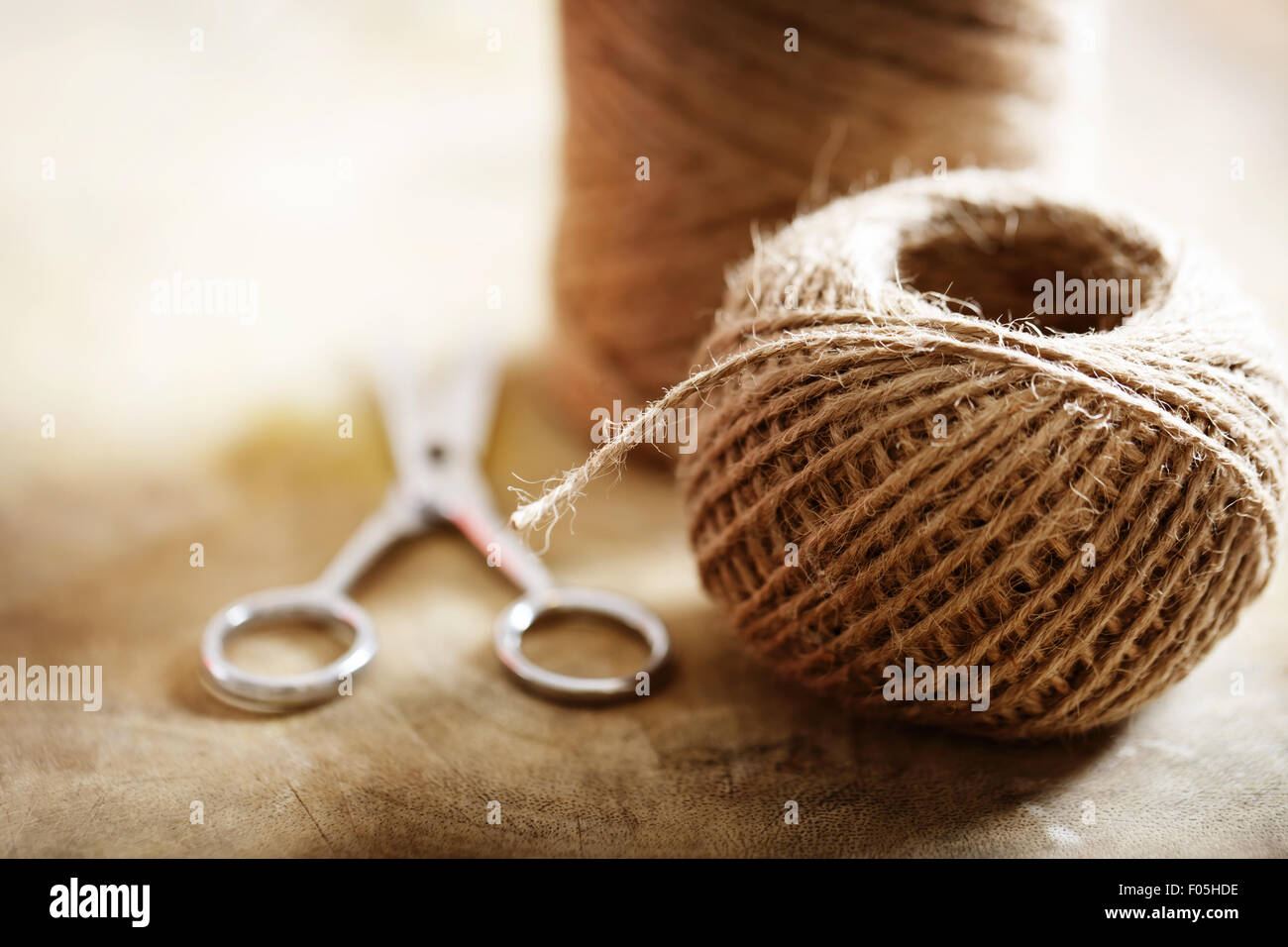 Twine cord with scissors on rustic wooden table Stock Photo - Alamy