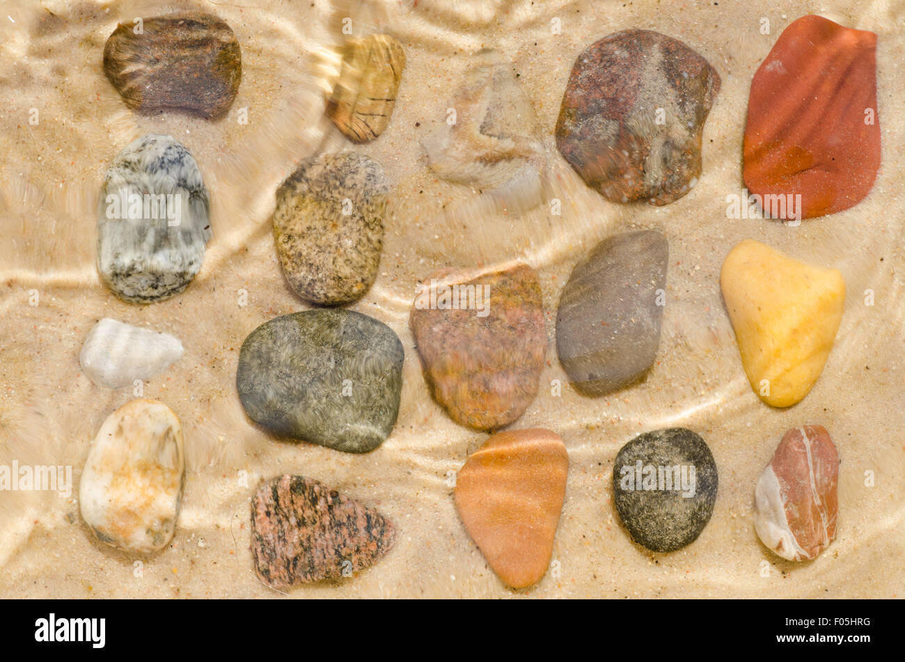 pebbles composition on sand background Stock Photo - Alamy
