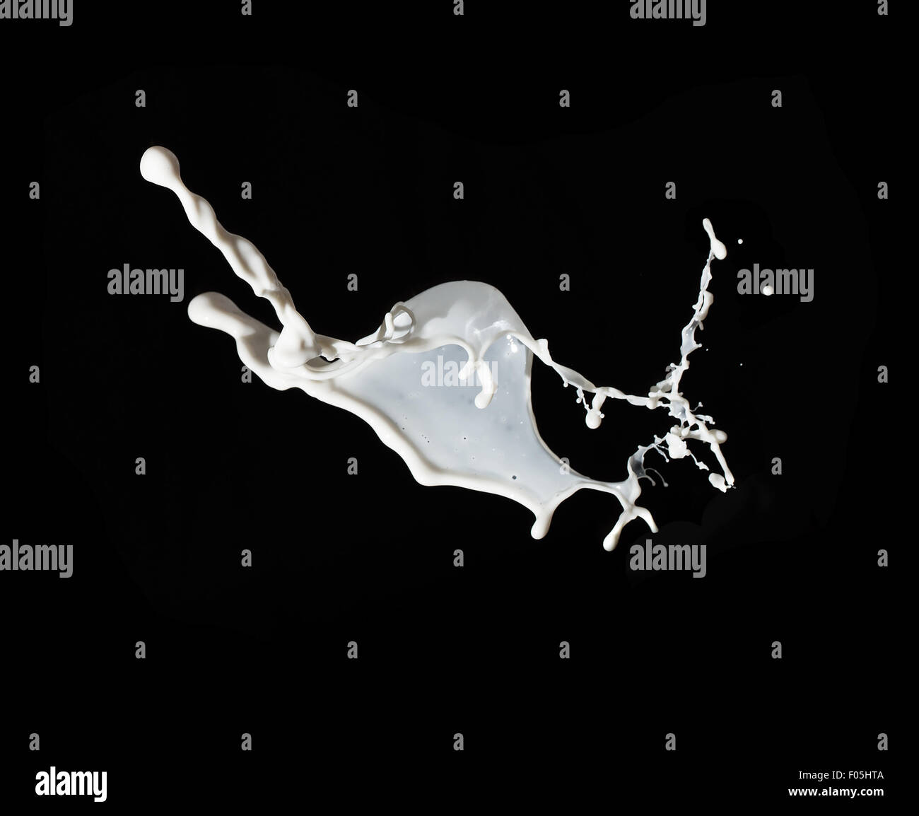 Milk splash isolated on a black background Stock Photo - Alamy