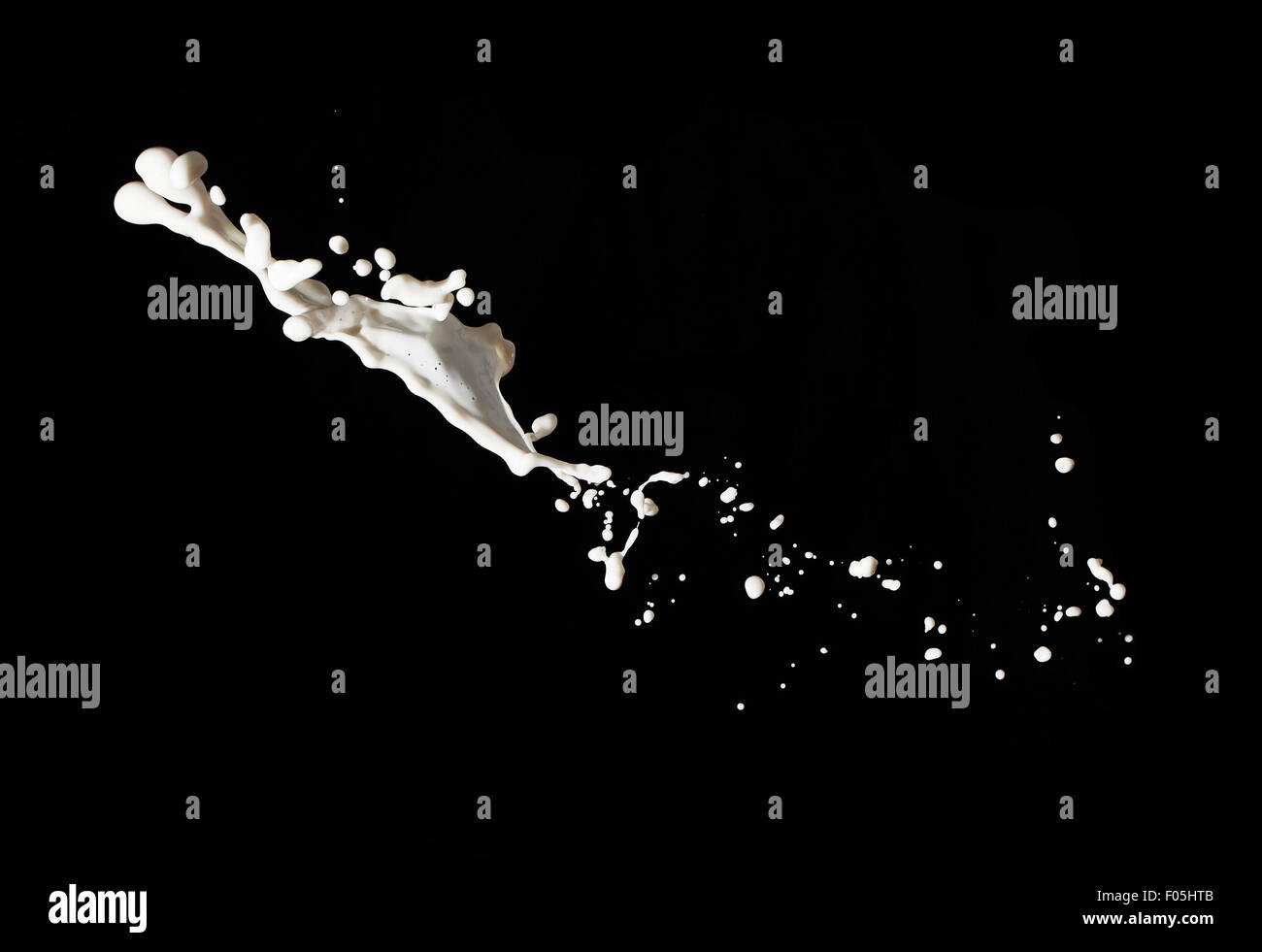 Milk splash isolated on a black background Stock Photo - Alamy