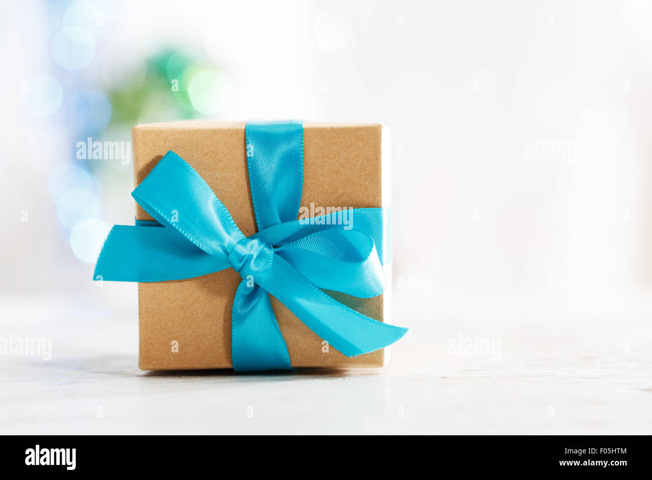 Gift box with blue ribbon in white wall room Stock Photo - Alamy