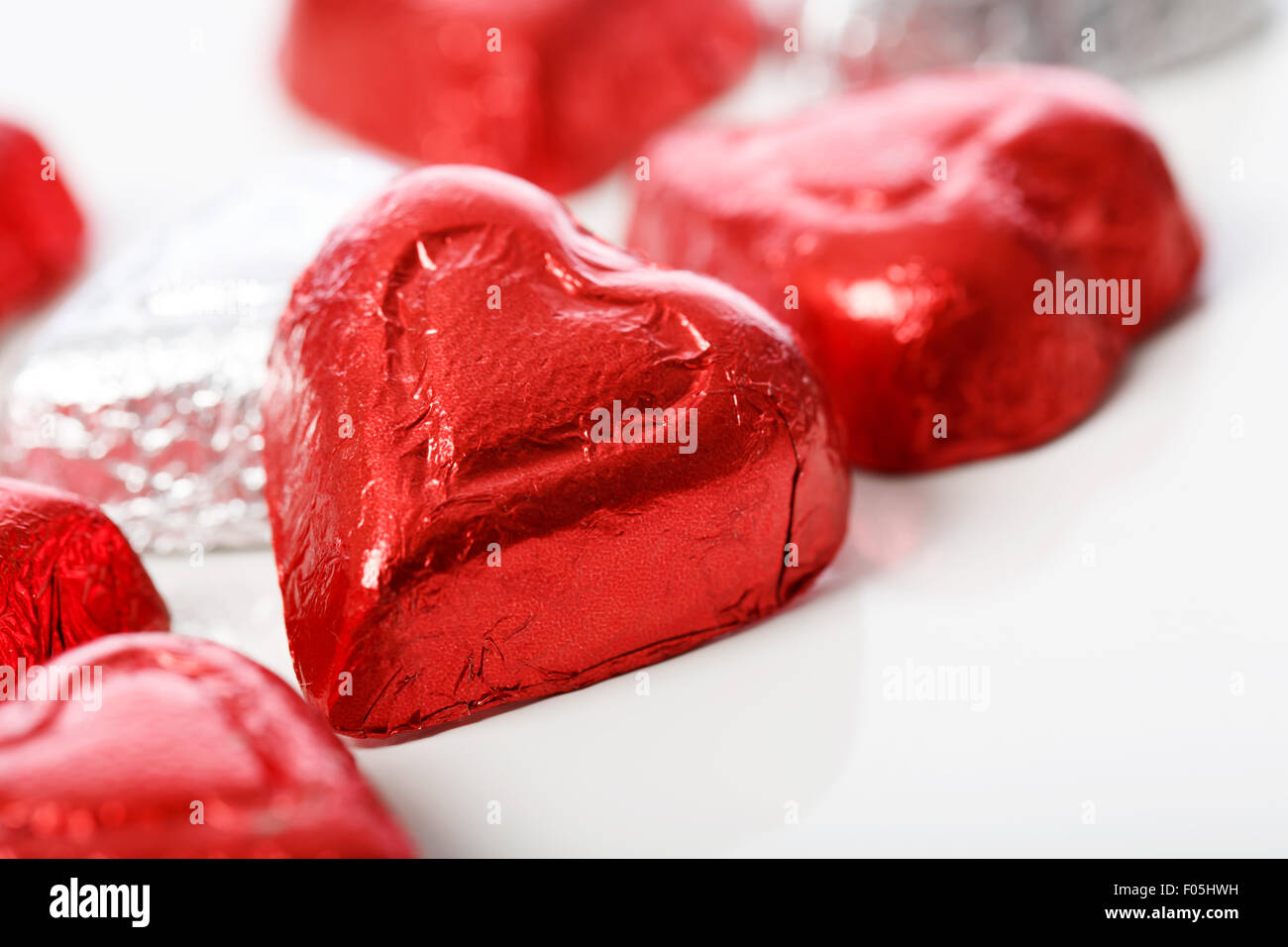Red heart shaped chocolates on white background Stock Photo - Alamy