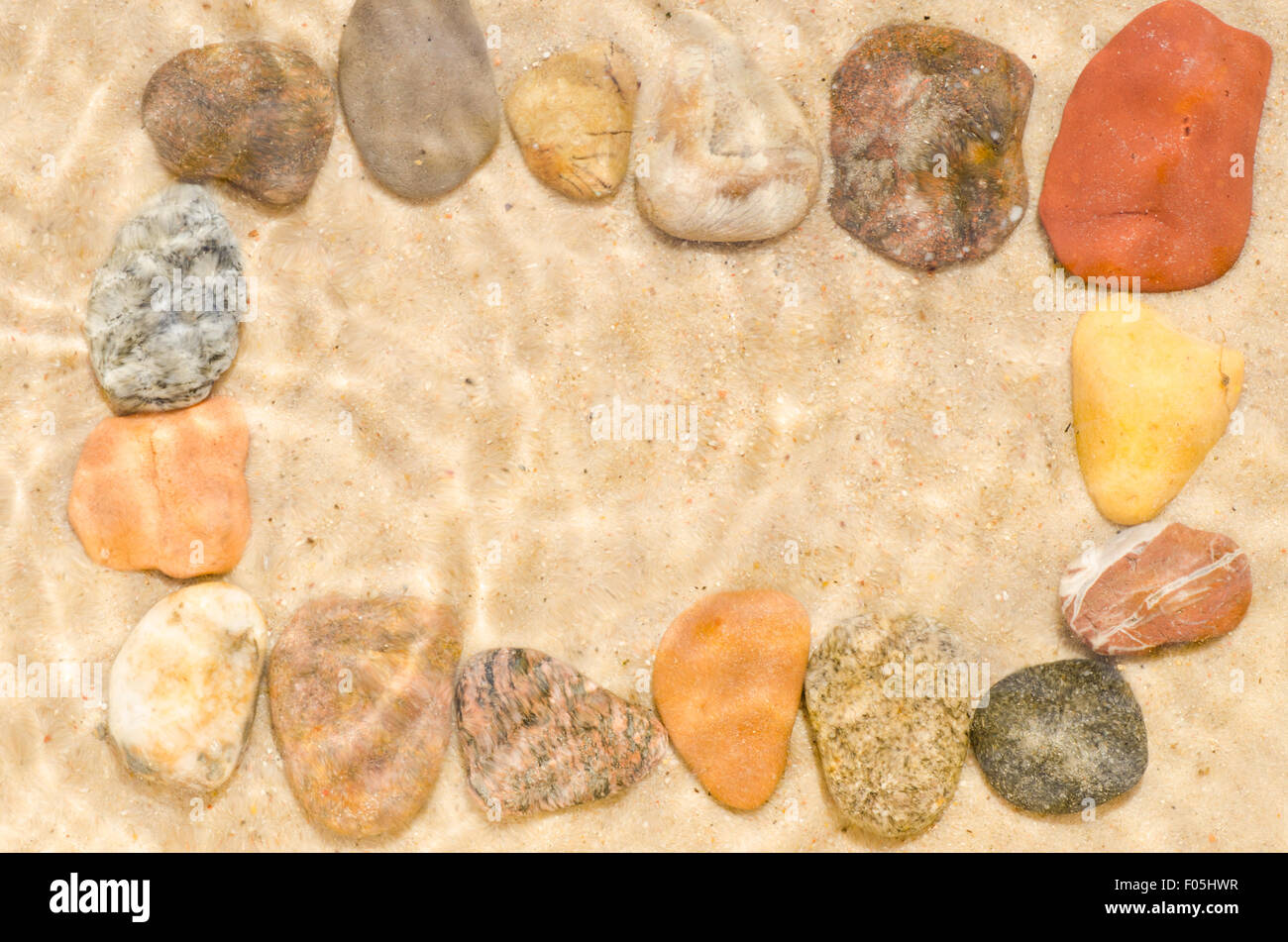 pebbles composition on sand background Stock Photo - Alamy