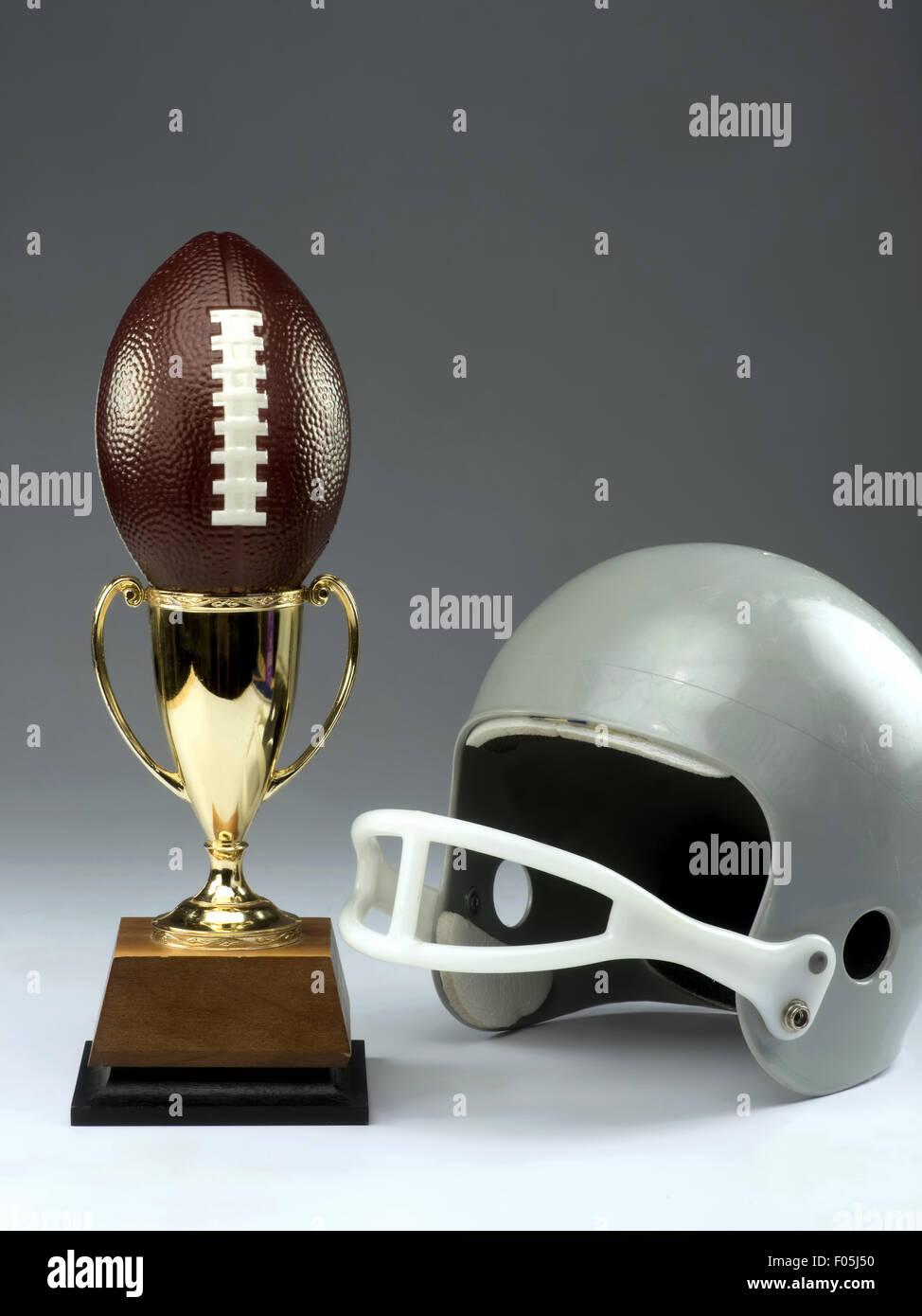 Youth football with winning trophy and helmet Stock Photo - Alamy
