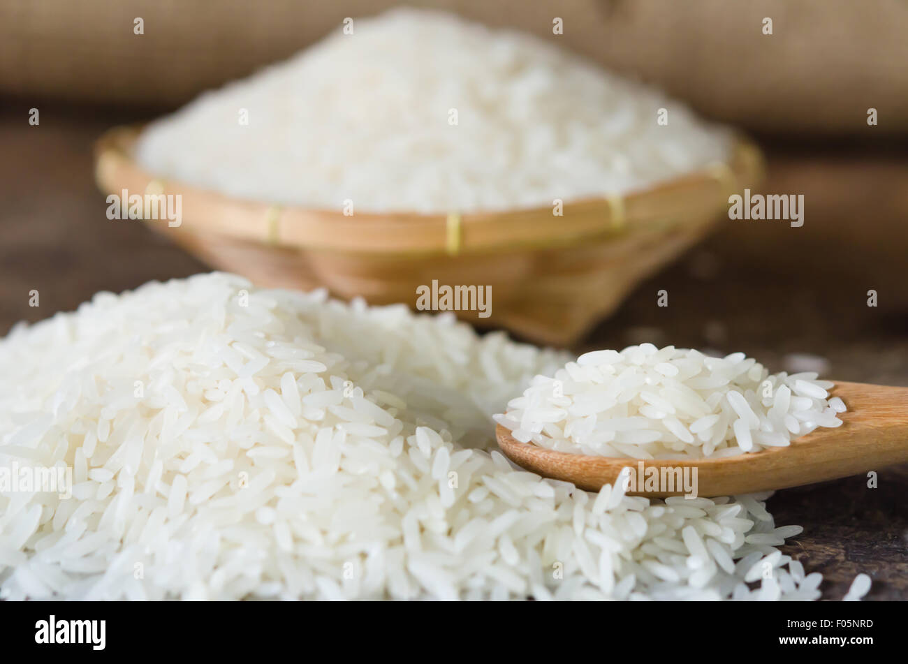 white rice grains with wooden spoon on wooden table Stock Photo - Alamy