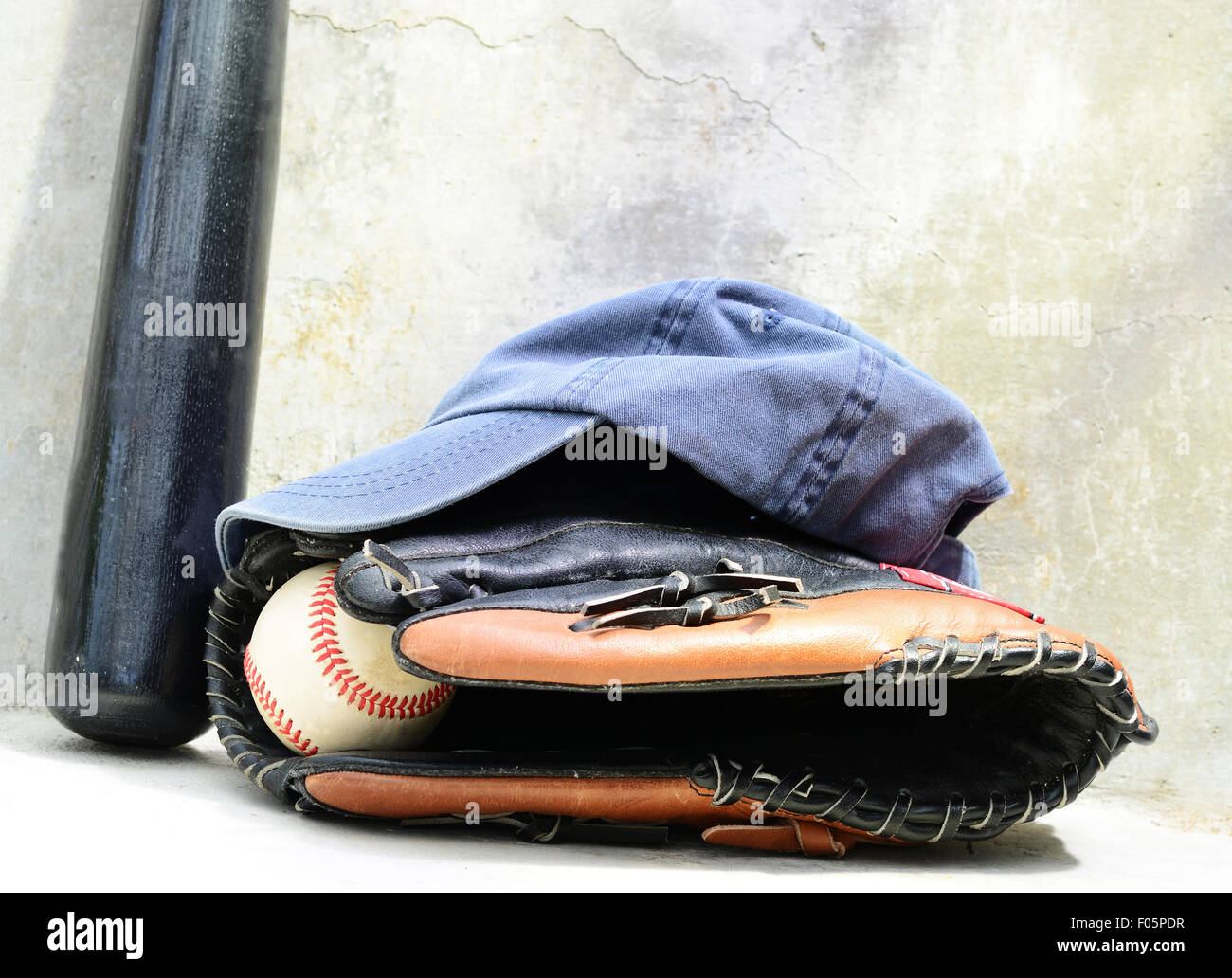 Baseball bat wit a cap and a glove with a ball in it Stock Photo - Alamy