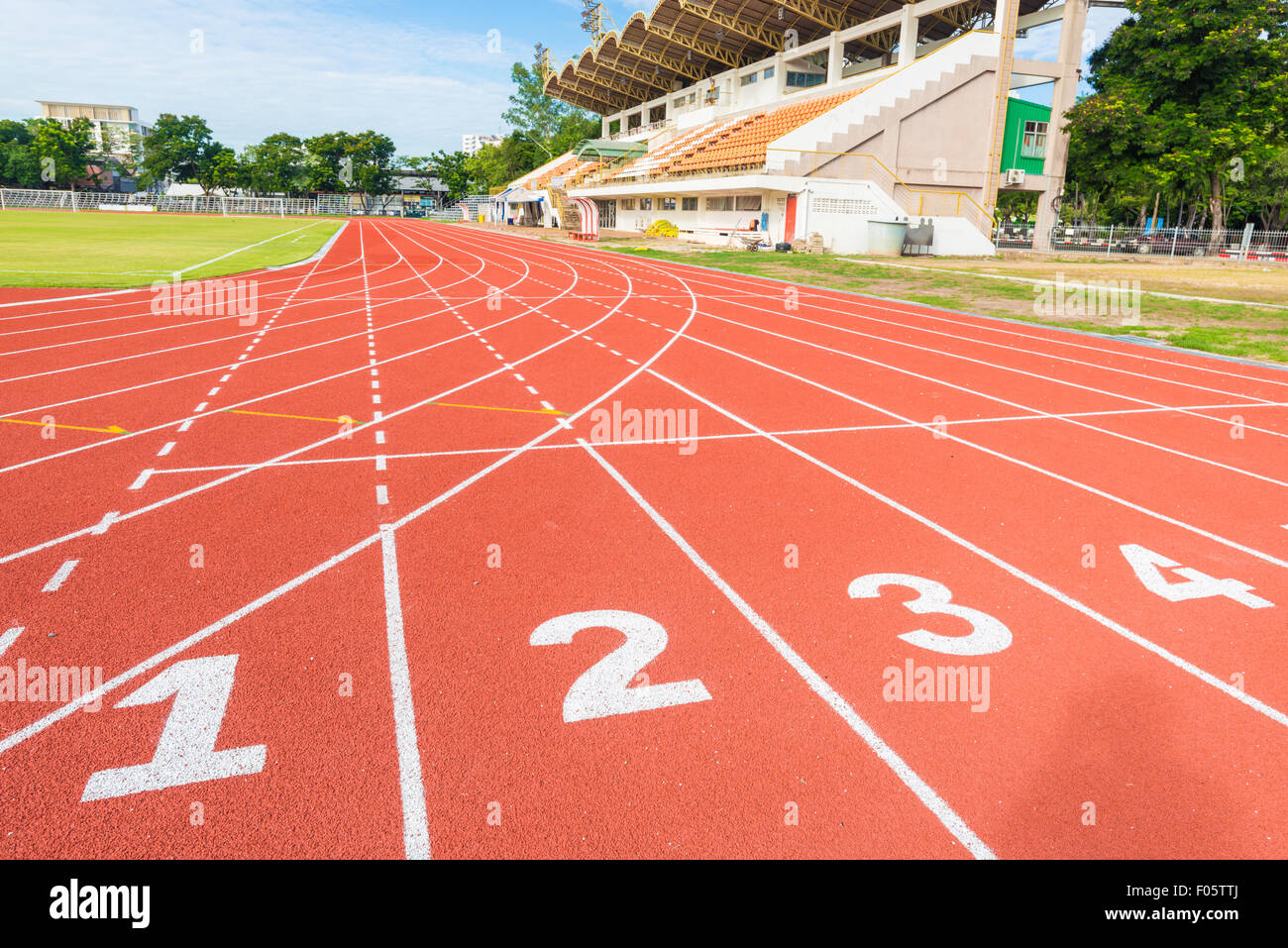 Running track with numbers over blue sky and clouds Stock Photo - Alamy