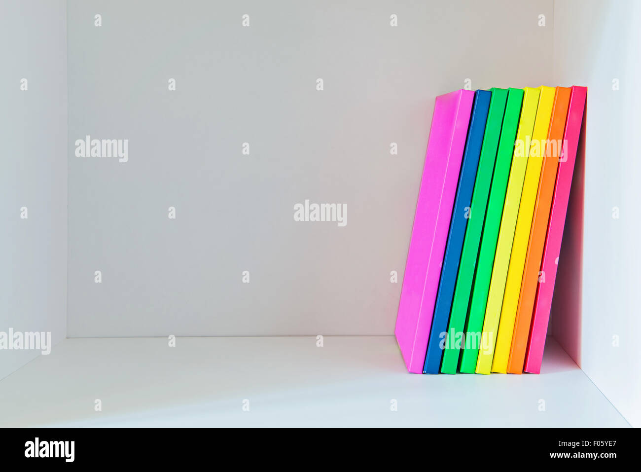 Multi colored books on the light-coloured bookshelf with copy-space Stock Photo - Alamy