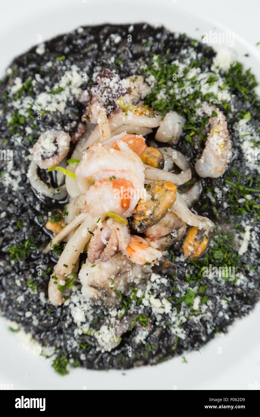 black risotto with seafood serving in restaurant Stock Photo - Alamy