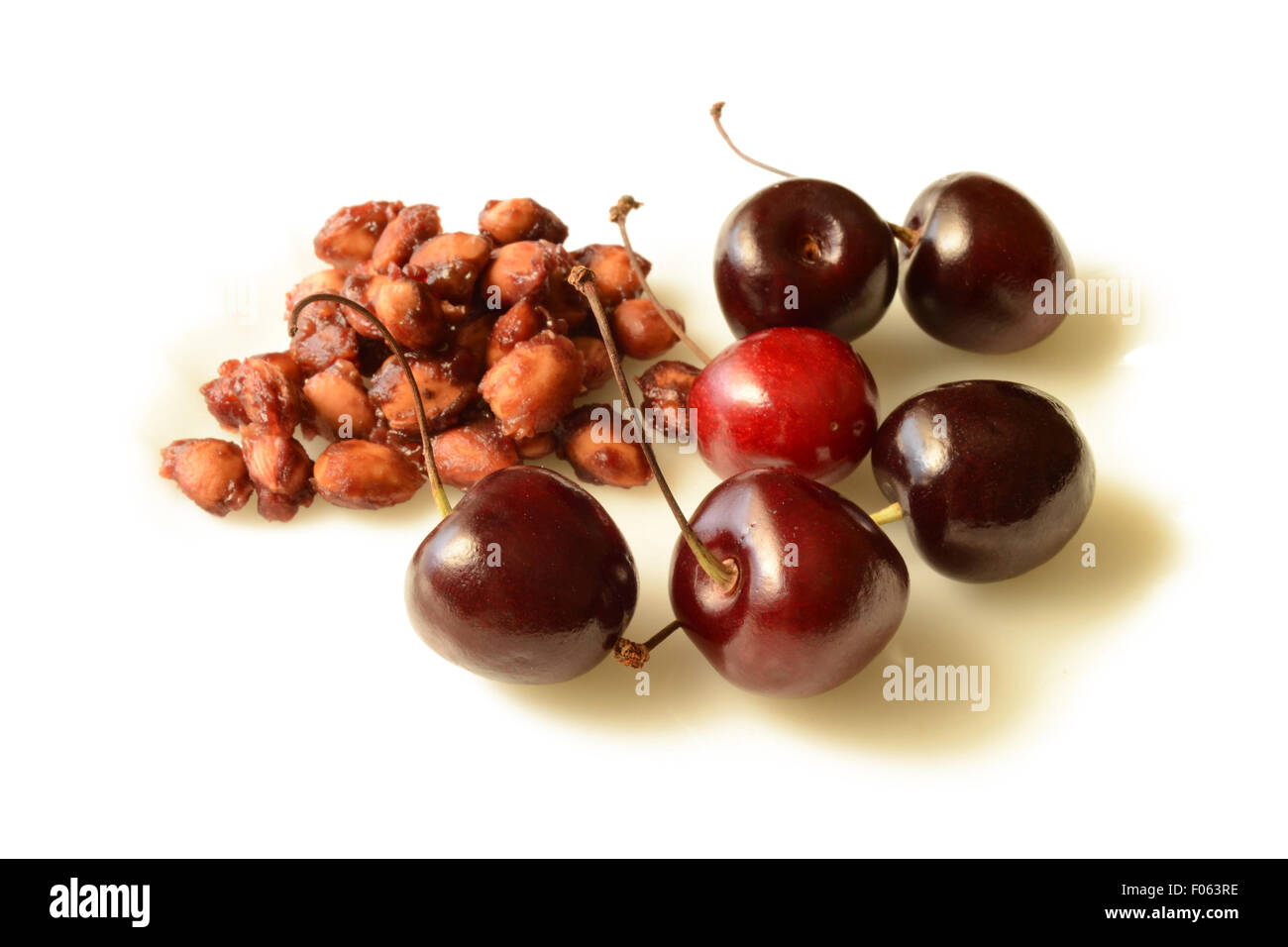 Cherries and cherry seeds on a white background Stock Photo - Alamy