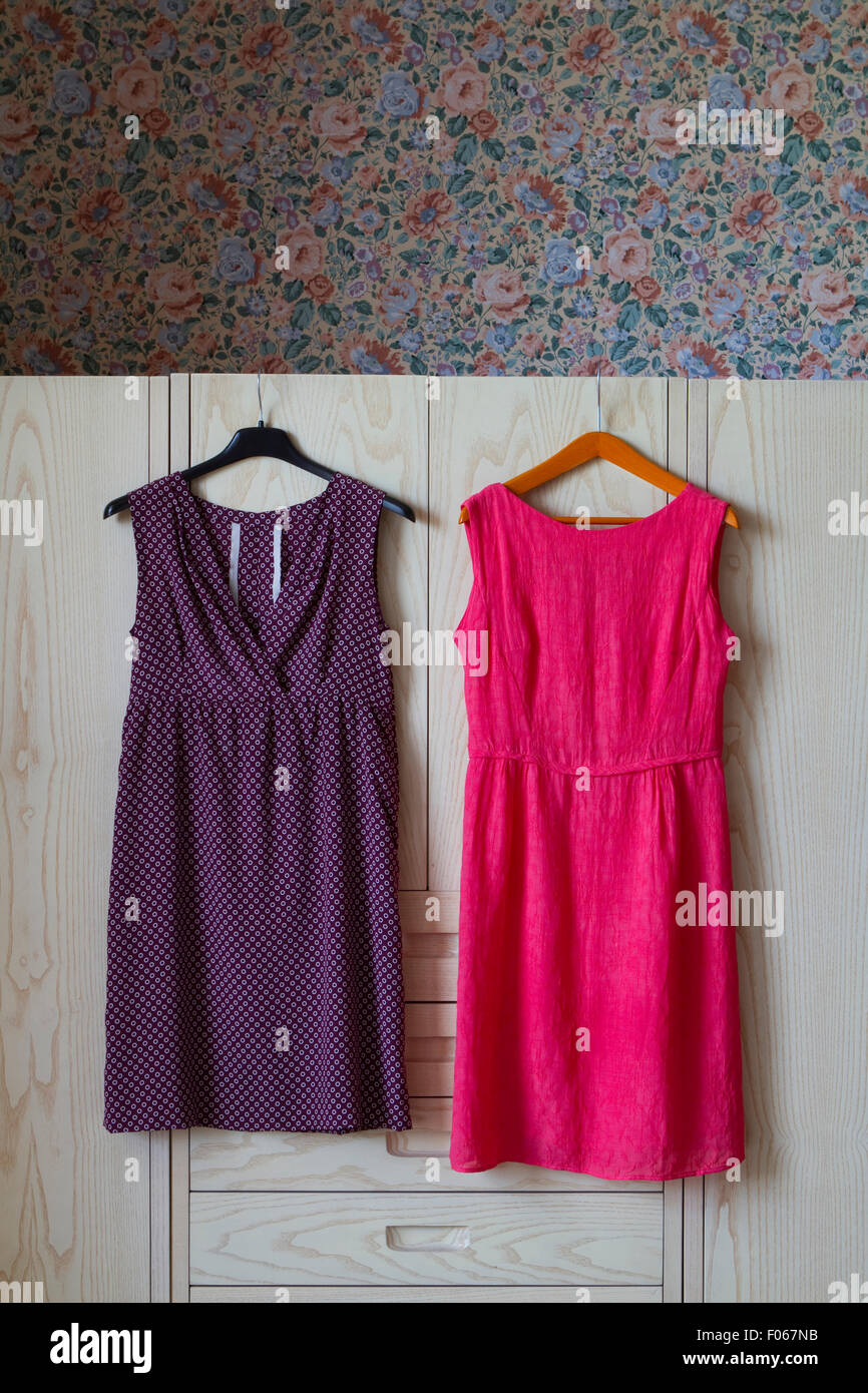 Two woman dresses hanging from a wardrobe Stock Photo - Alamy