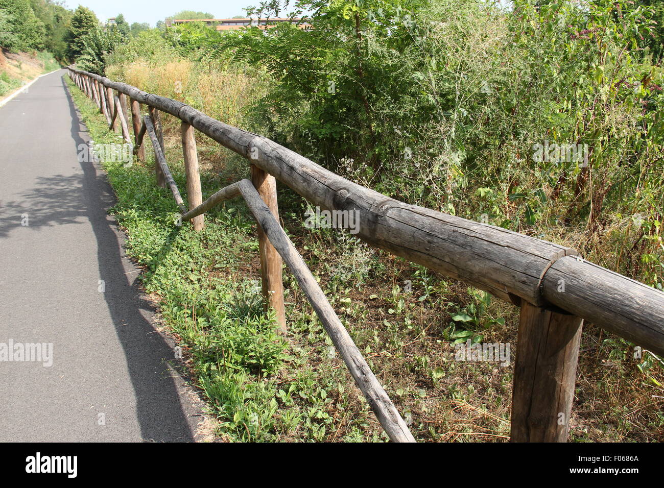 Wooden handrail follows bike path, asphalt. Diaphragm down Stock Photo ...