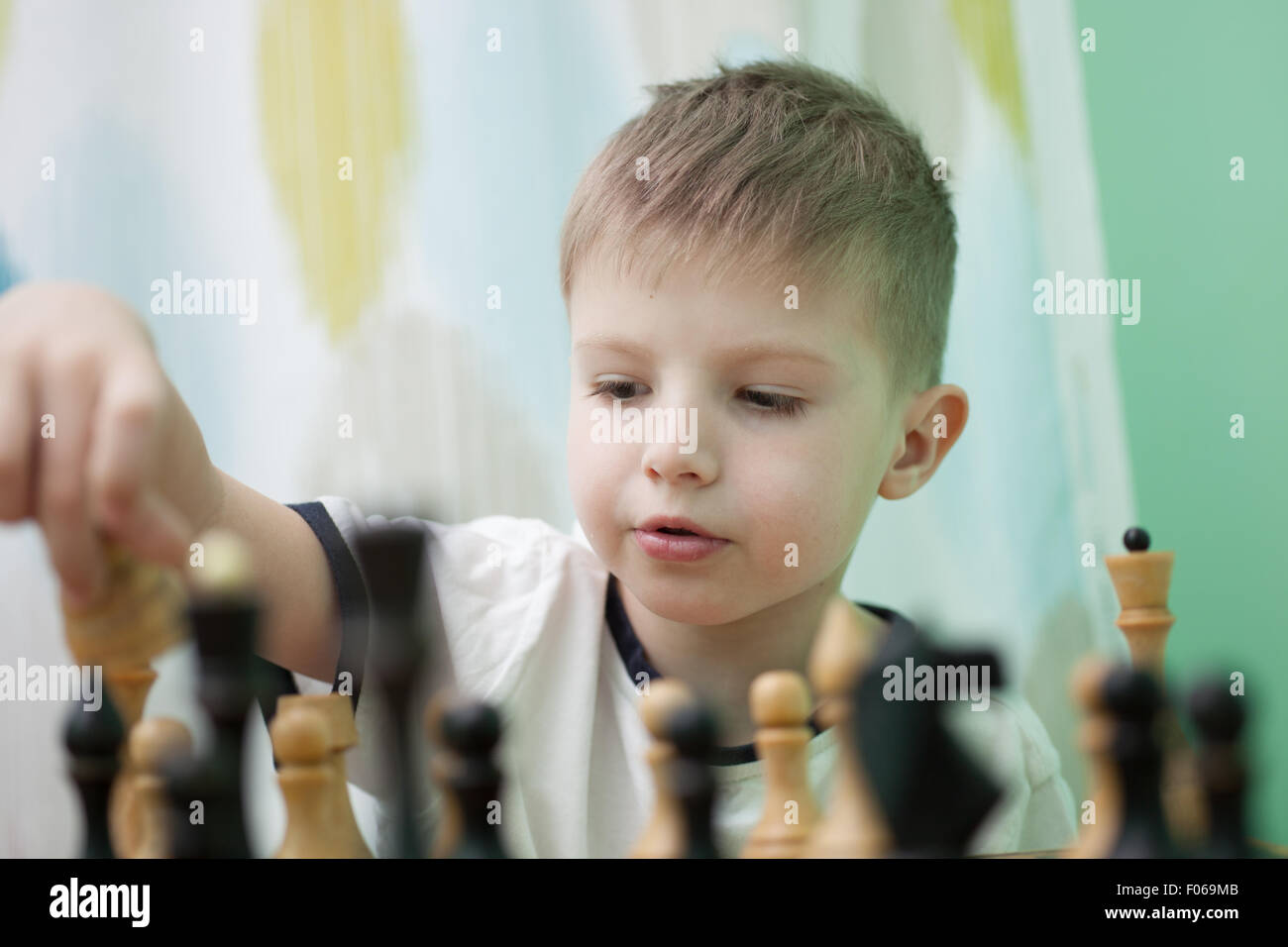 Portrait of a little boy playing chess Stock Photo - Alamy