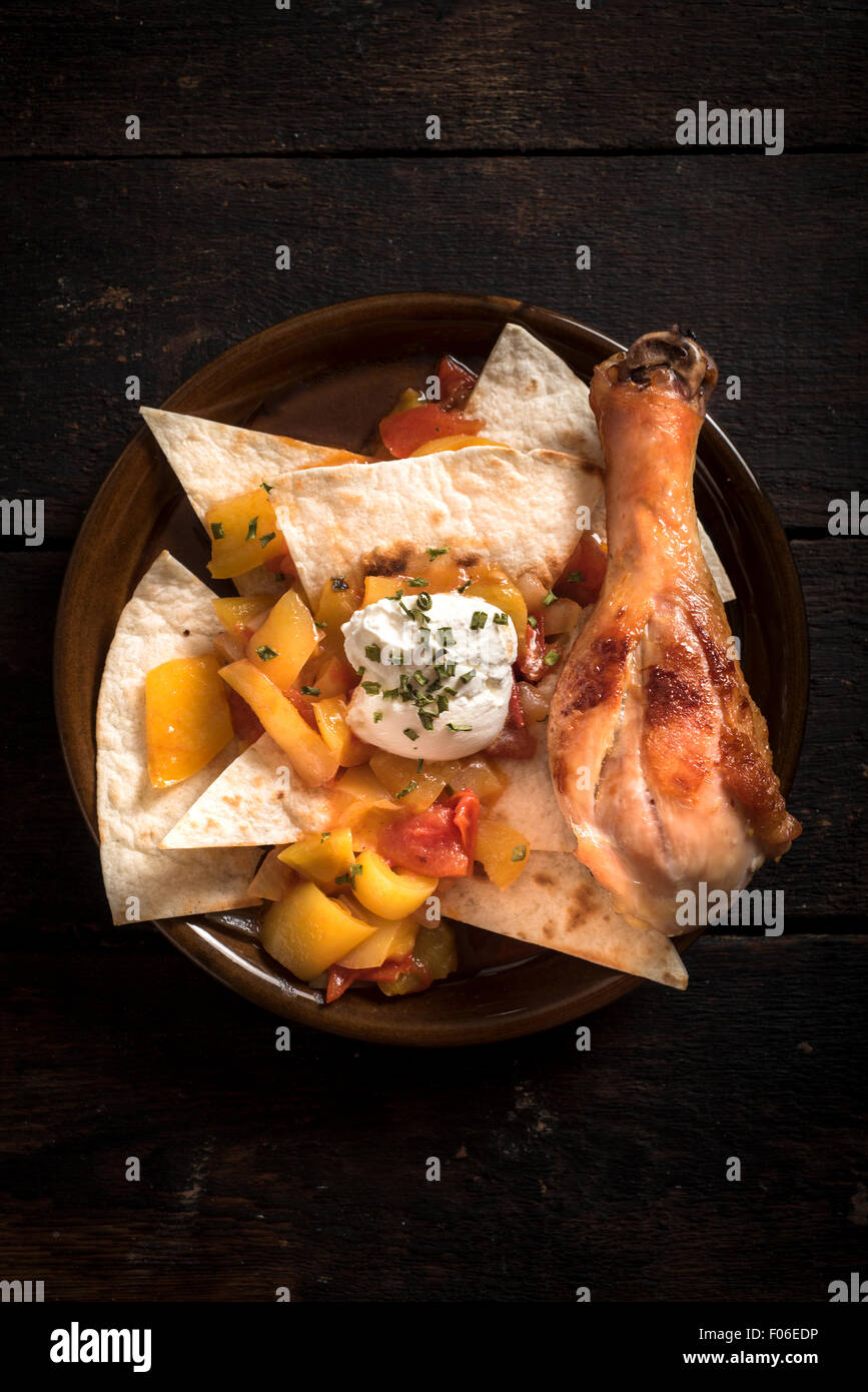 Chicken drumstick and tortilla bread in the plate,from above on wooden ...