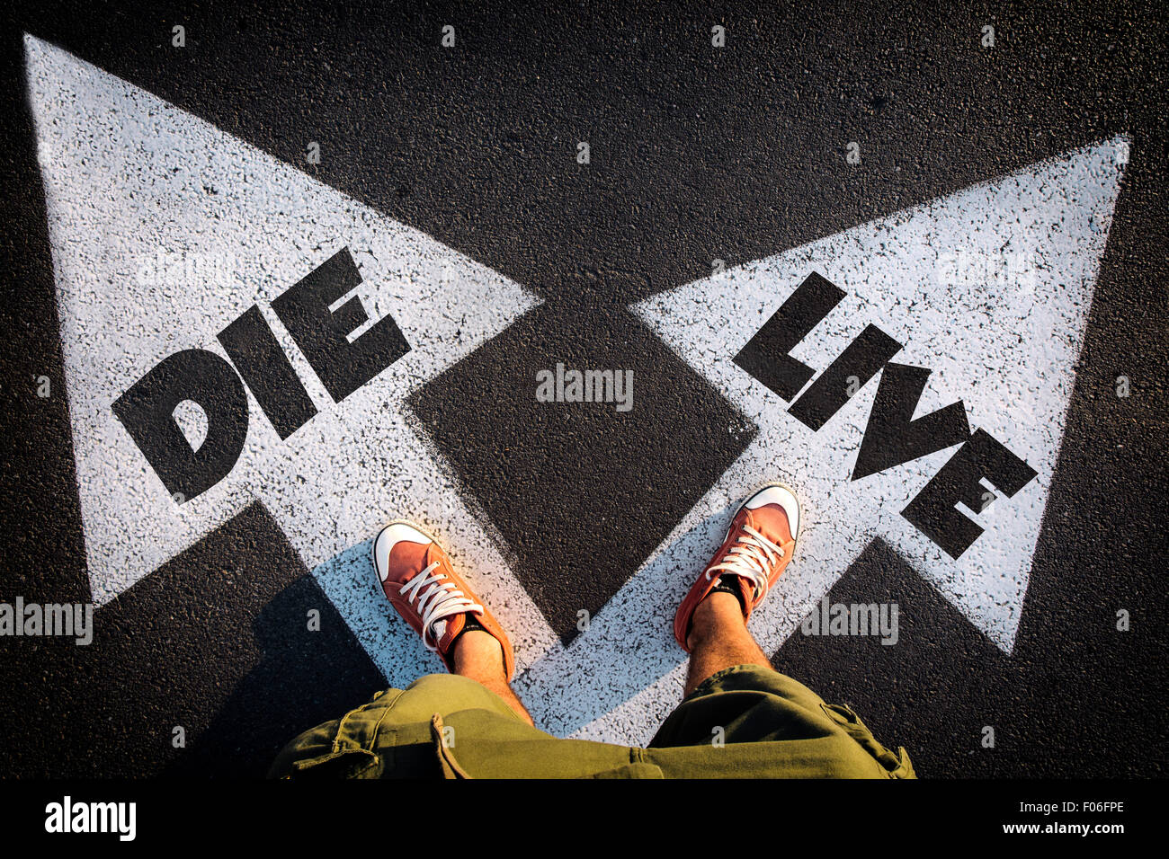 Live or die dilemma concept with man legs from above standing on signs ...
