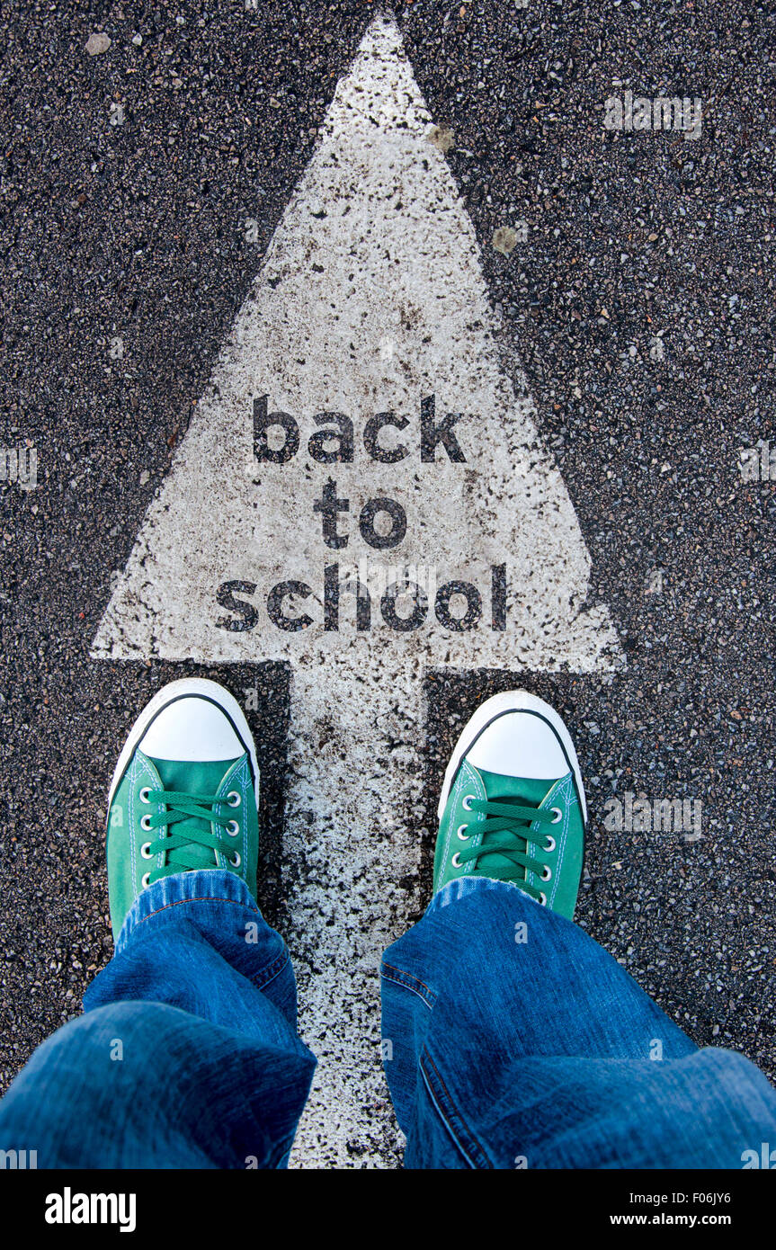 Student standing above the sign back to school Stock Photo - Alamy