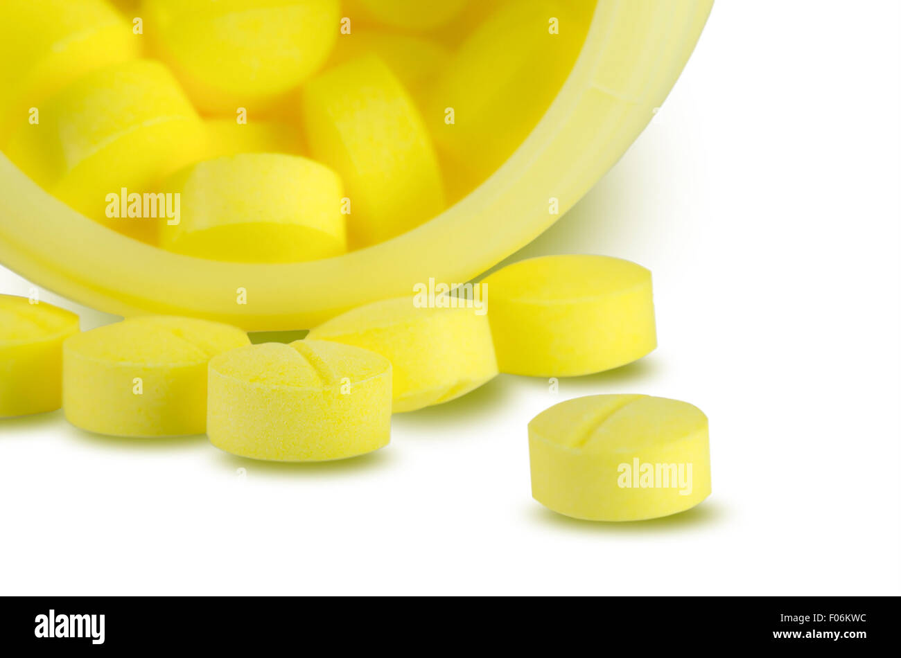 Yellow medicine pills and bottle on white background with selective ...