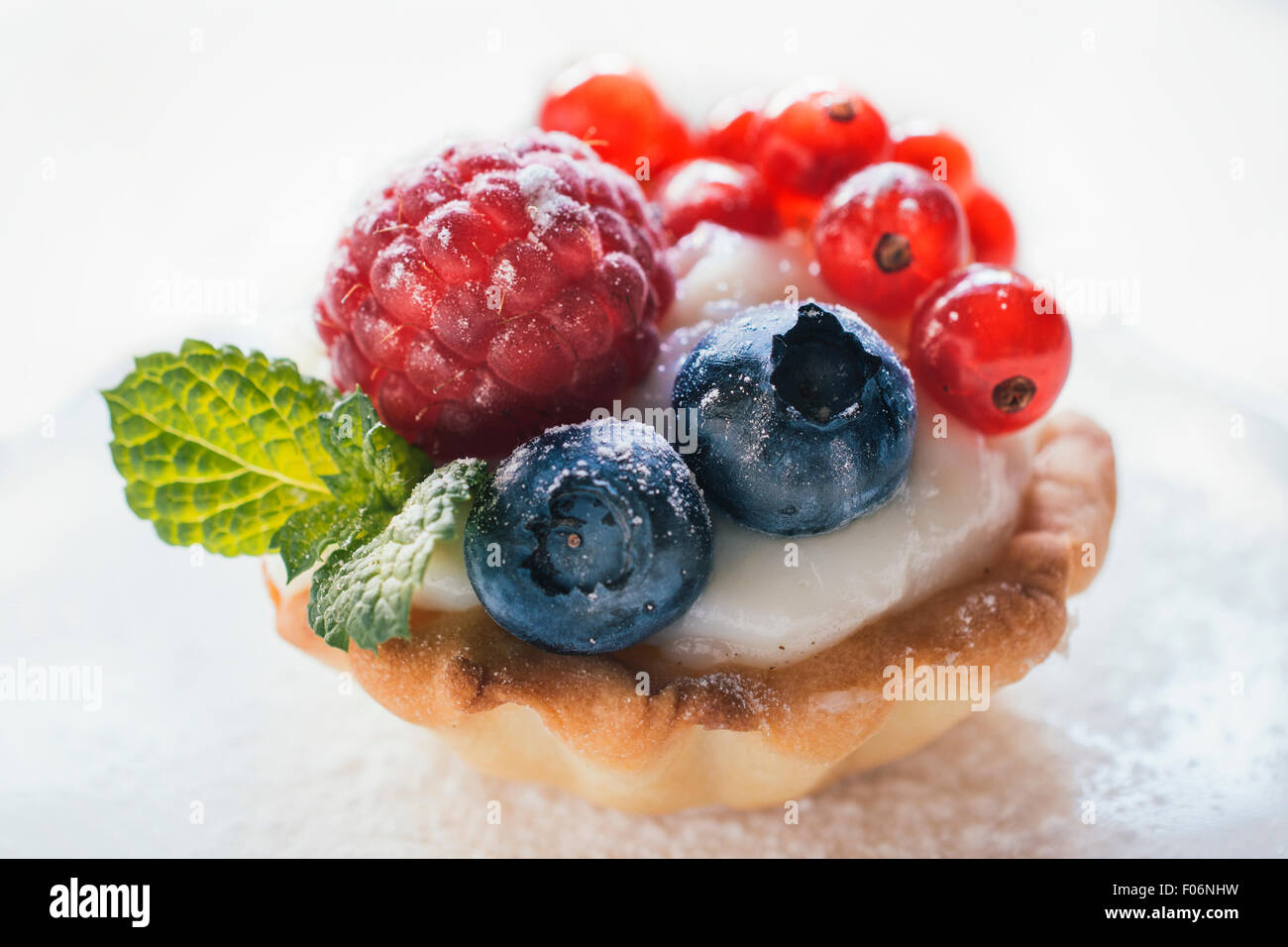 Close up to mini tart stuffed with vanilla pudding and berry fruits ...