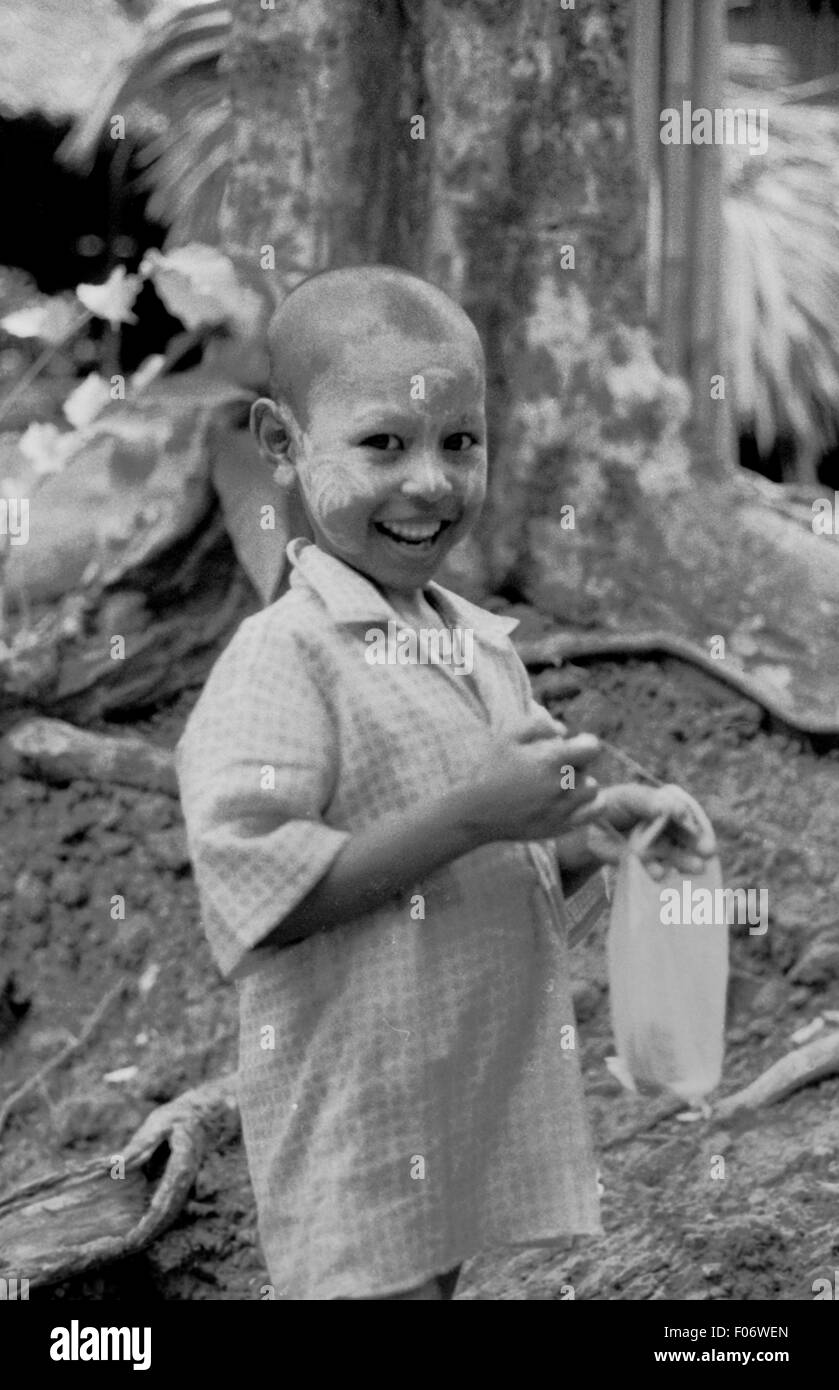 child covered in traditional face powder with drink in plastic bag ...