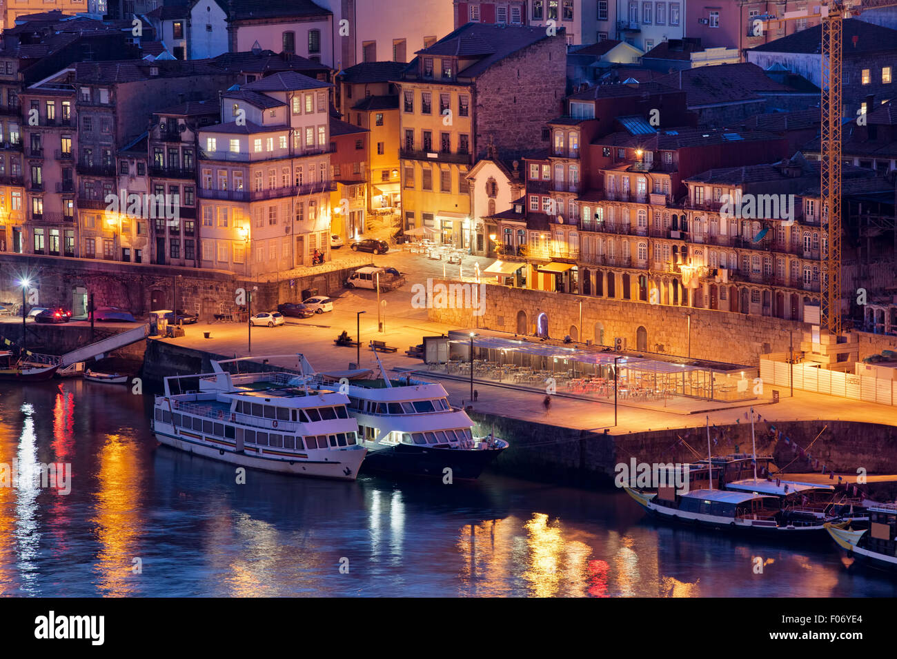 Porto in Portugal by night, houses and cruise boats along Douro river ...