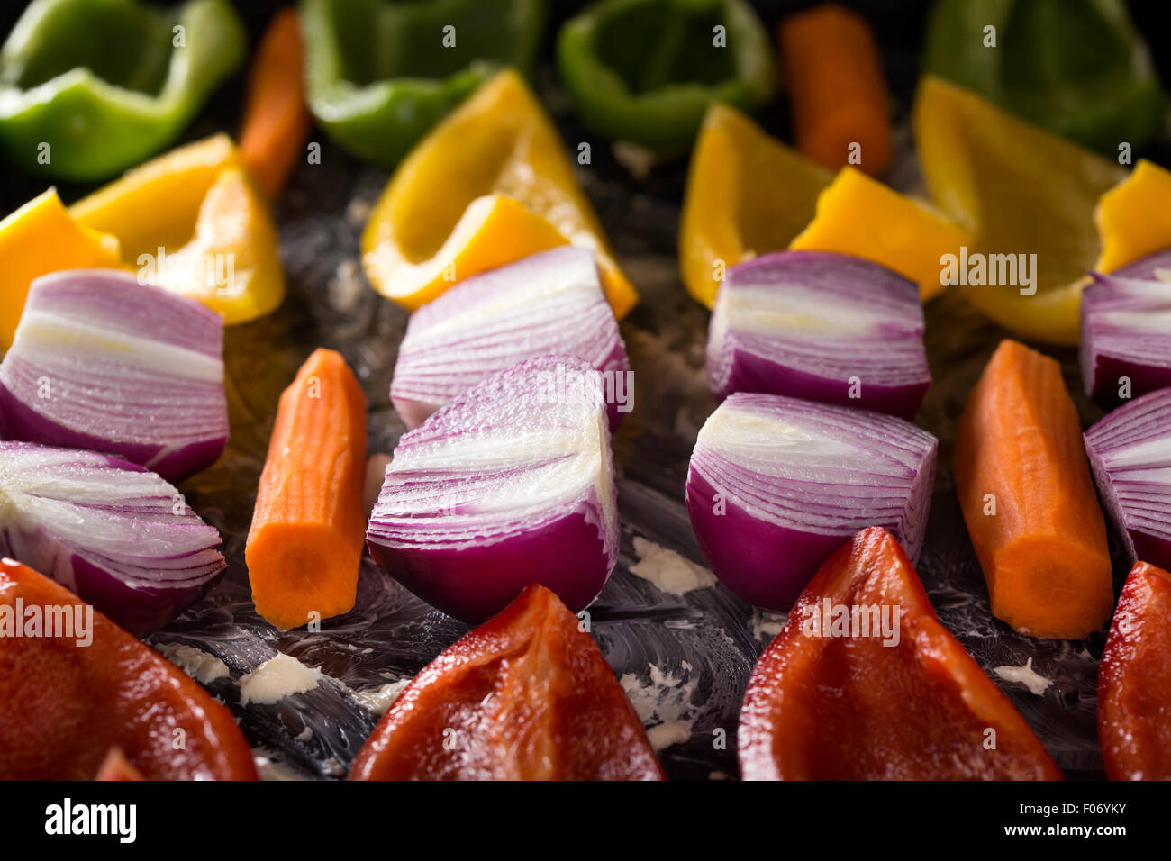 Raw vegetables in a metallic tray with butter, ready to be roasted ...