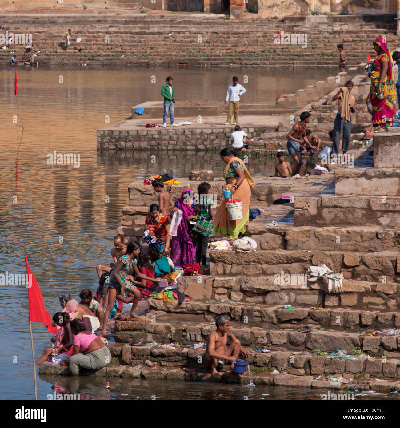 Locals bathing and washing clothing at a ghat at Khajuraho giving ...