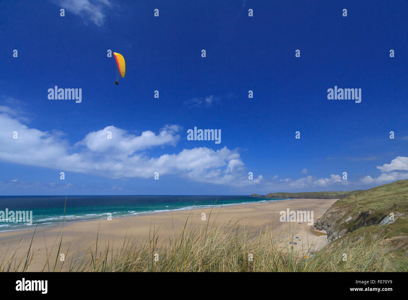 A paraglider soars high over Perran Beach and Perran Bay, near ...