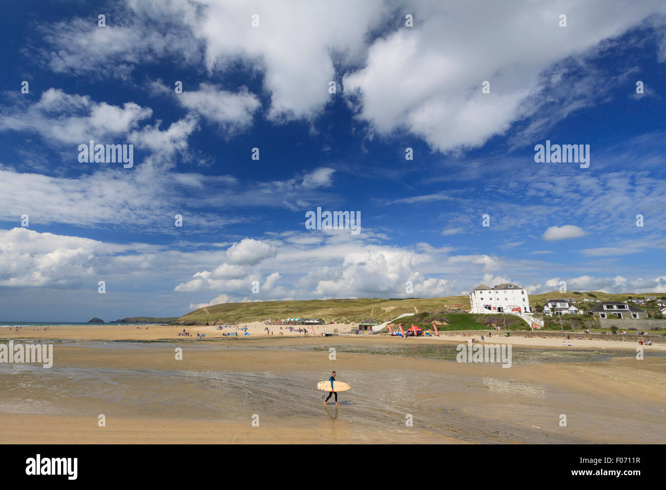 A surfer walks across Perran Beach in central Perranporth, Cornwall ...