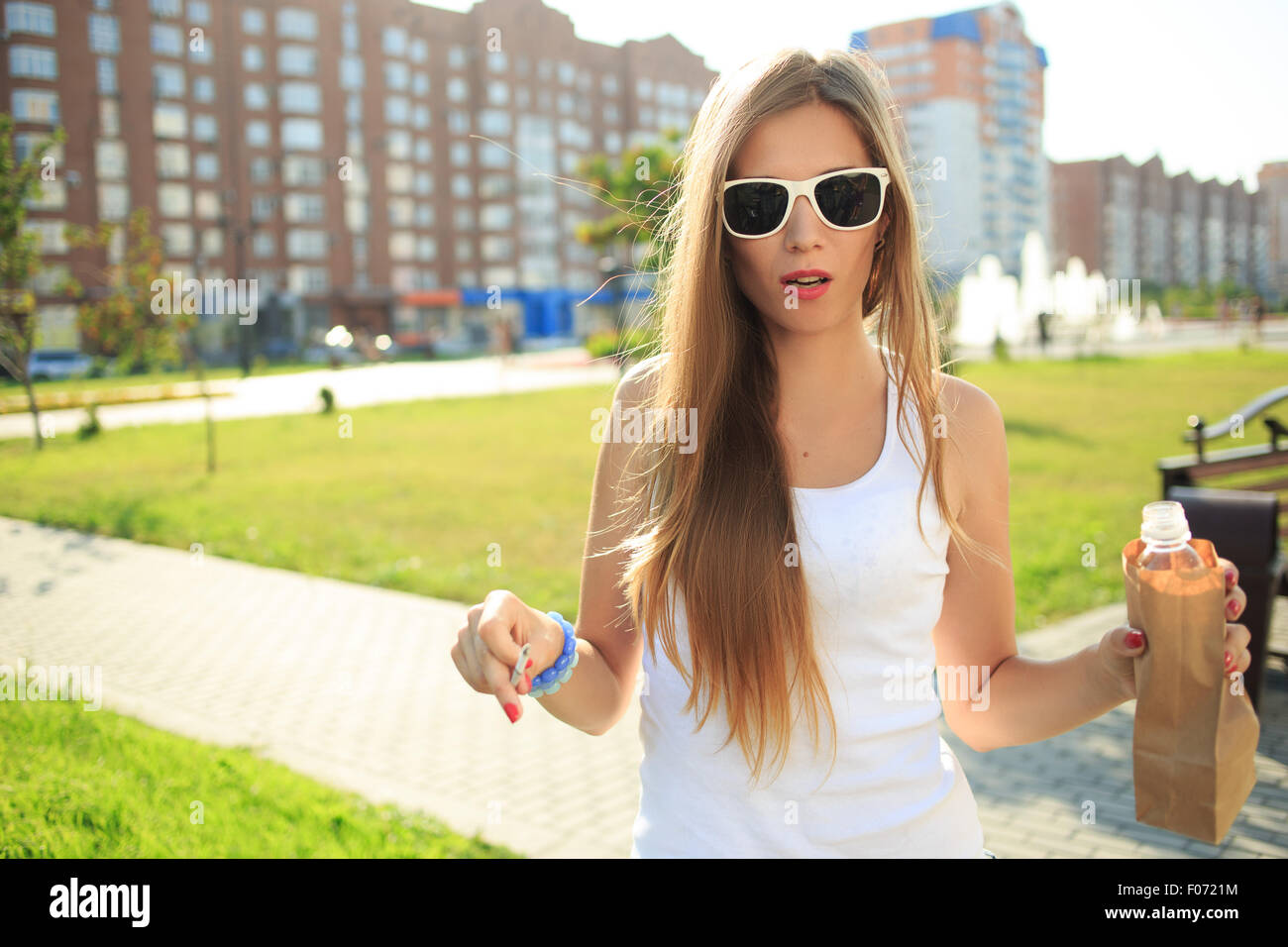 girl drinking from a paper bag in the street. smokes Stock Photo - Alamy